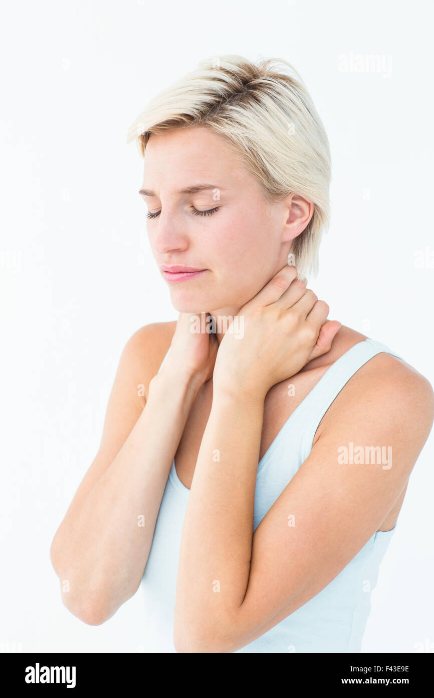 Wincing woman suffering from neck ache Stock Photo - Alamy