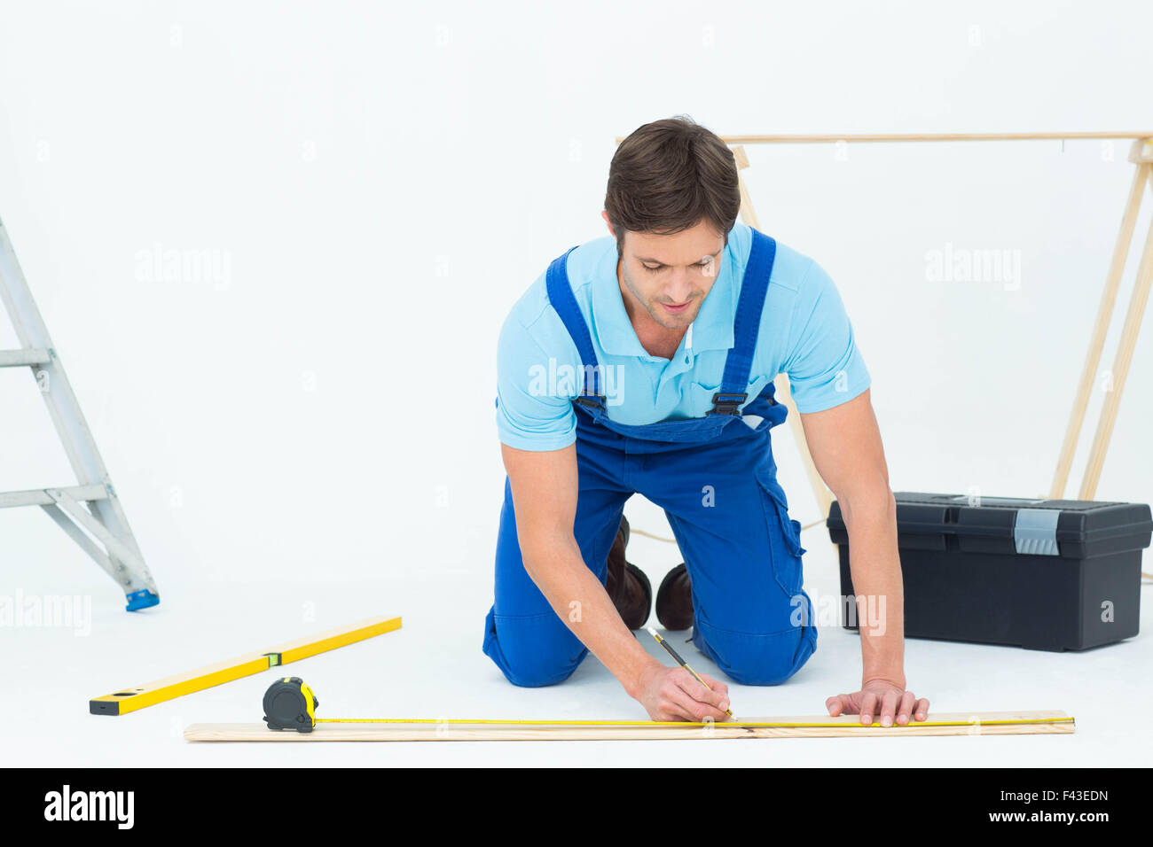 Worker marking on wood while measuring Stock Photo - Alamy