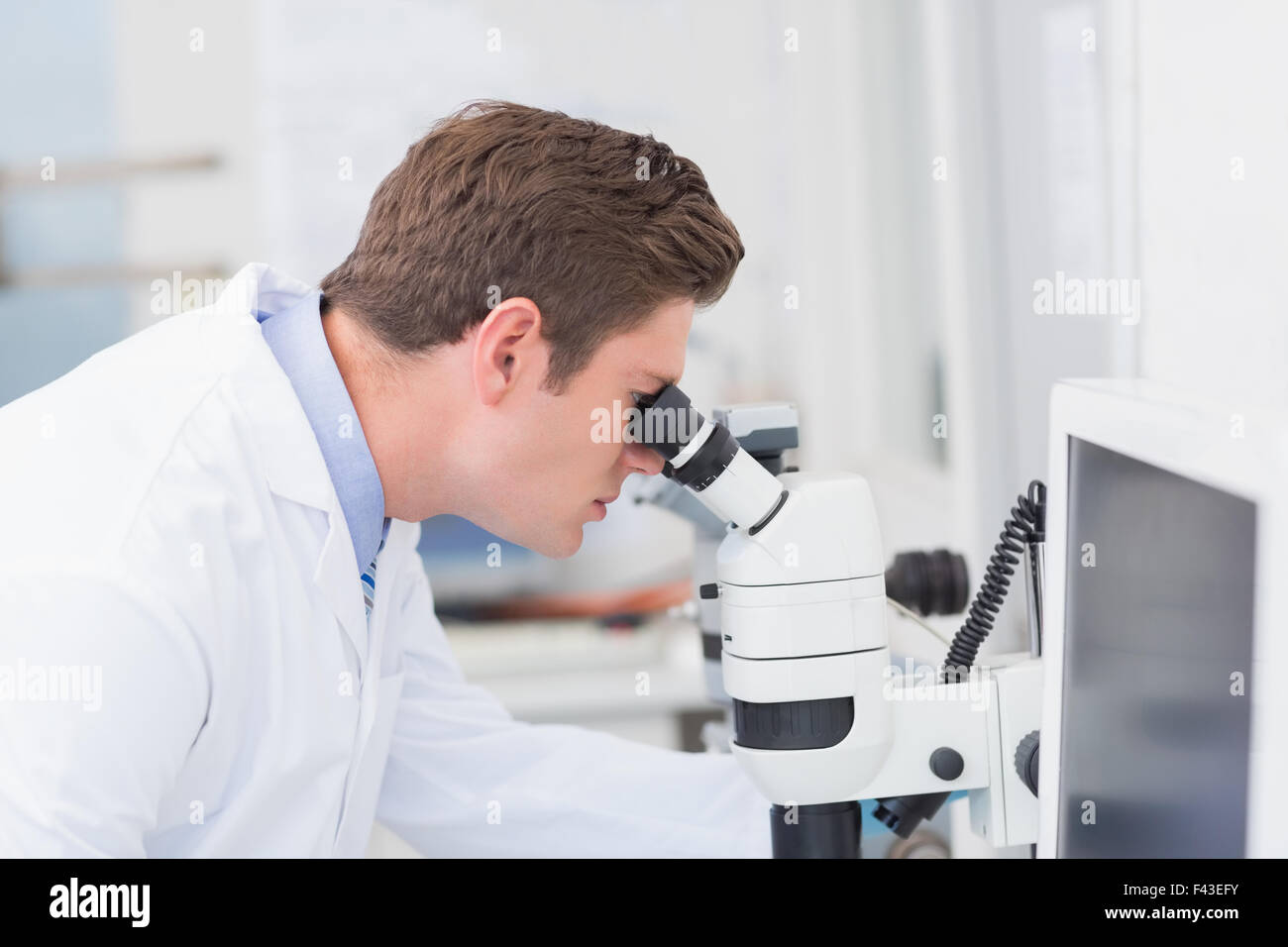Scientist looking in microscope Stock Photo - Alamy