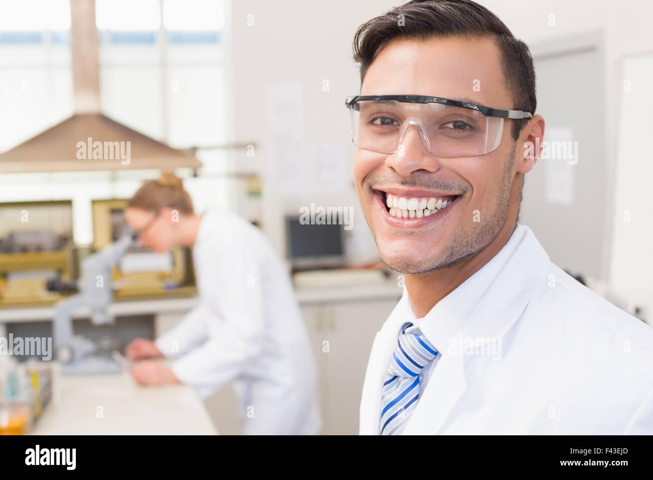 Smiling woman scientist using microscope hi-res stock photography and ...