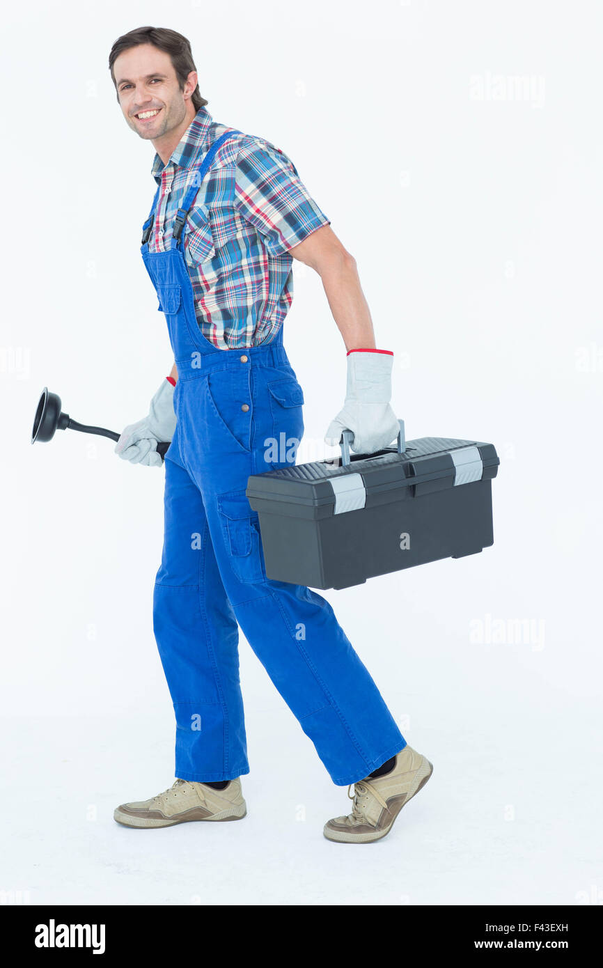 Plumber carrying plunger and tool box Stock Photo - Alamy