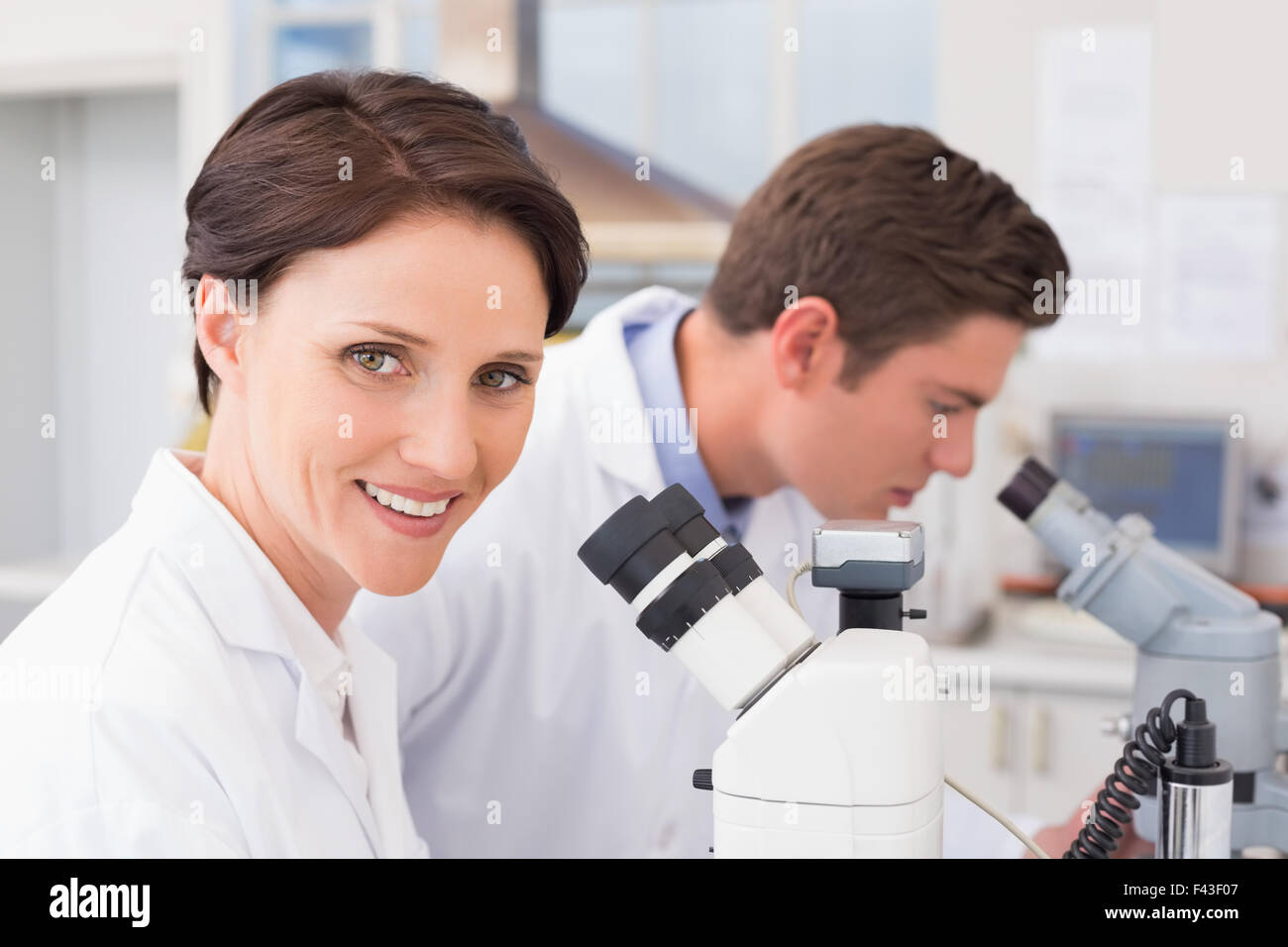 Scientists looking attentively in microscopes Stock Photo - Alamy