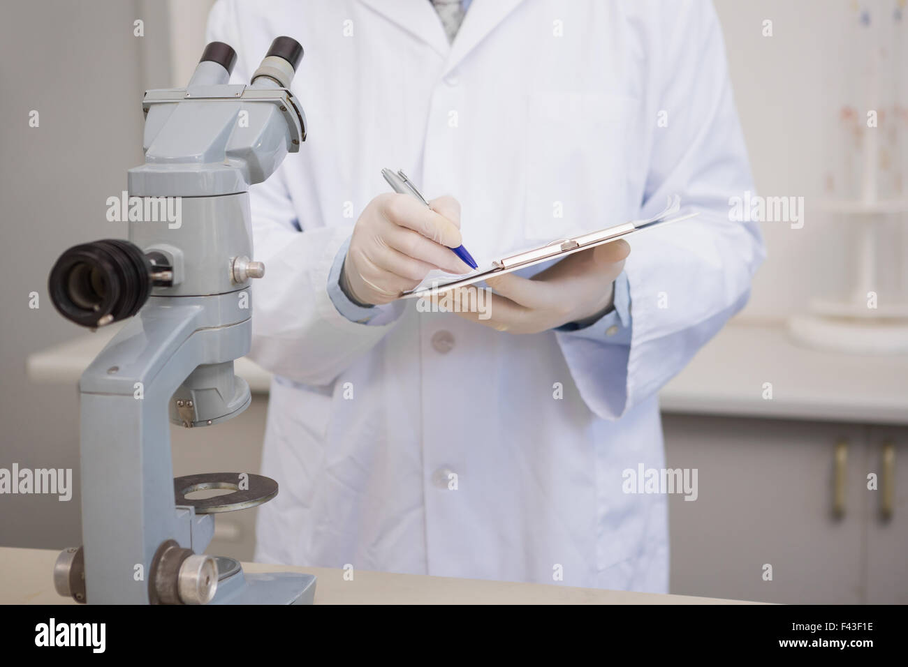 Scientist writing on clipboard Stock Photo - Alamy