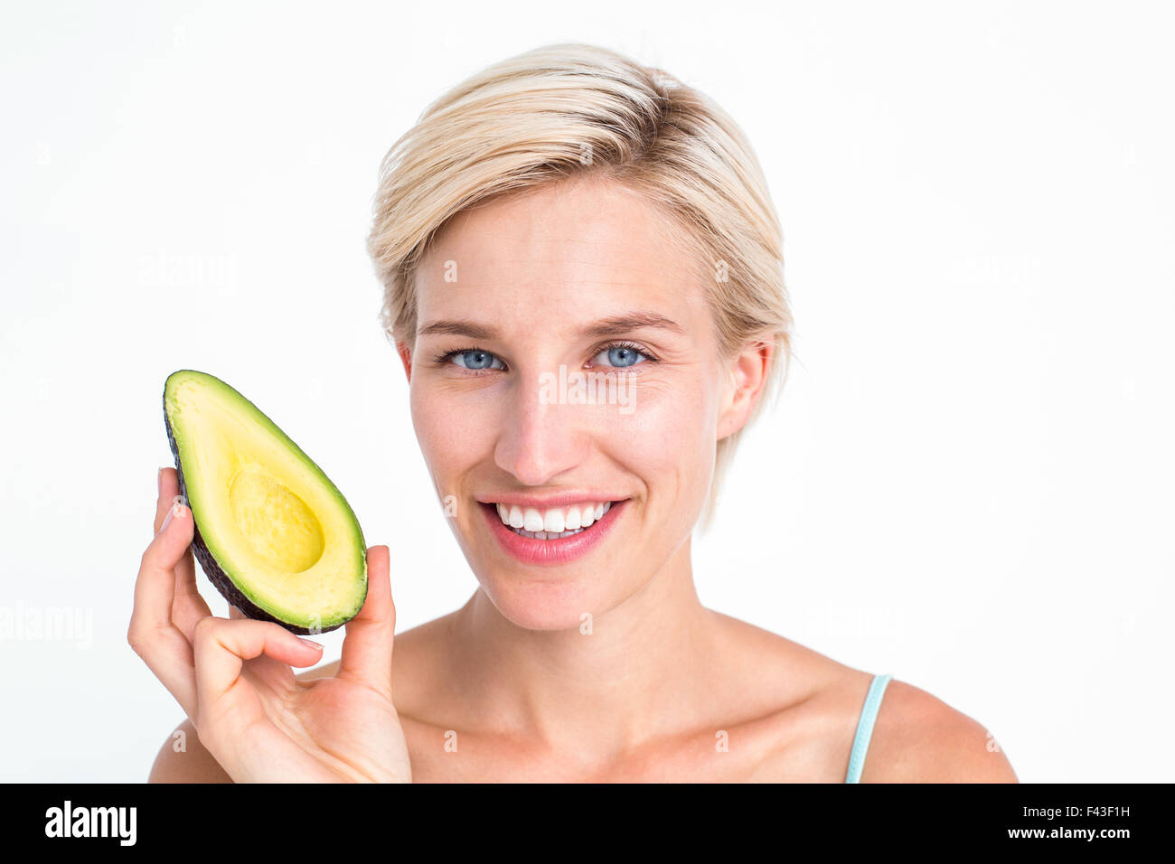 Pretty blonde holding half of an avocado Stock Photo - Alamy