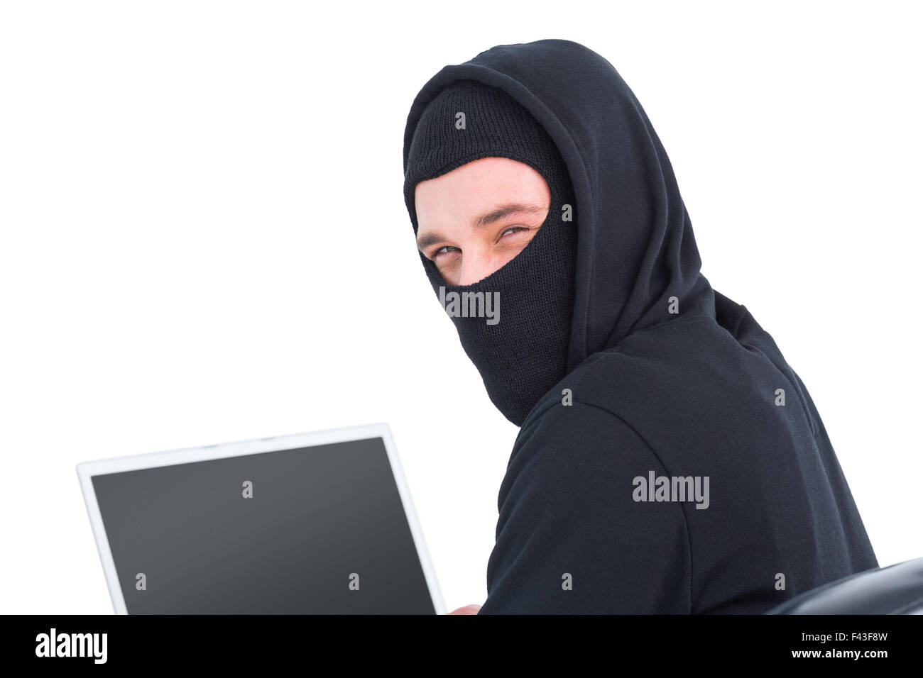 Hacker using laptop and looking at camera Stock Photo - Alamy