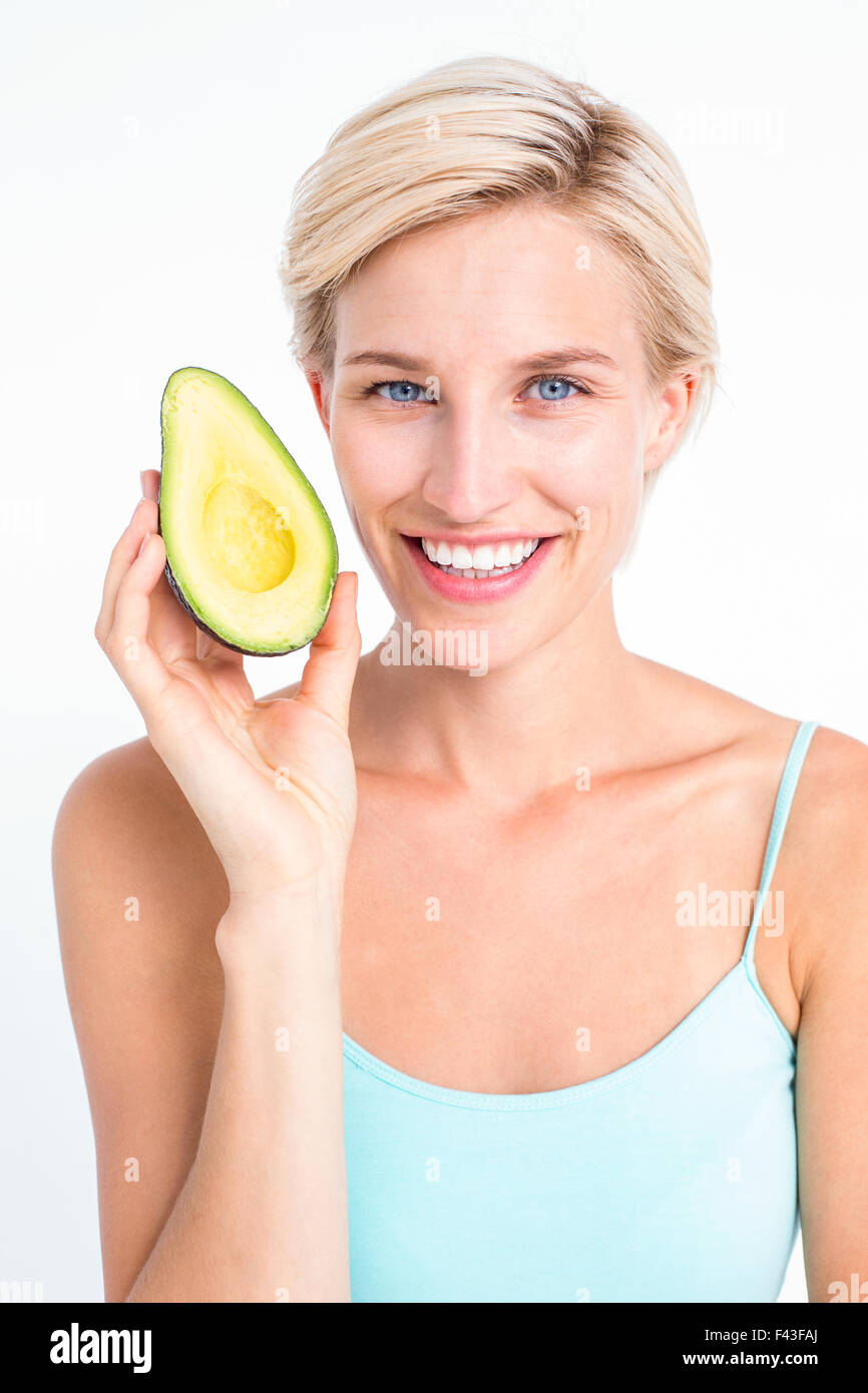 Pretty blonde holding half of an avocado Stock Photo - Alamy