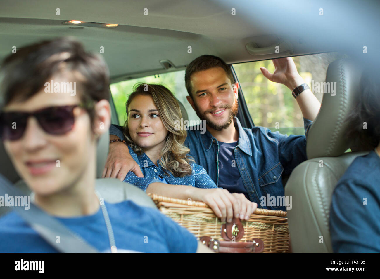 A group of people inside a car, two in the back seat and two in the ...