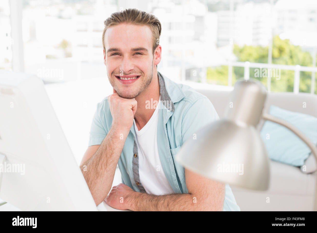 Smiling man using computer at his desk Stock Photo - Alamy