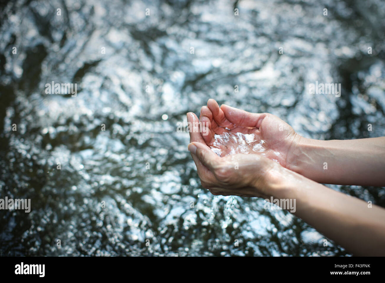 A man cupping his hands and scooping up clear water from a river Stock ...