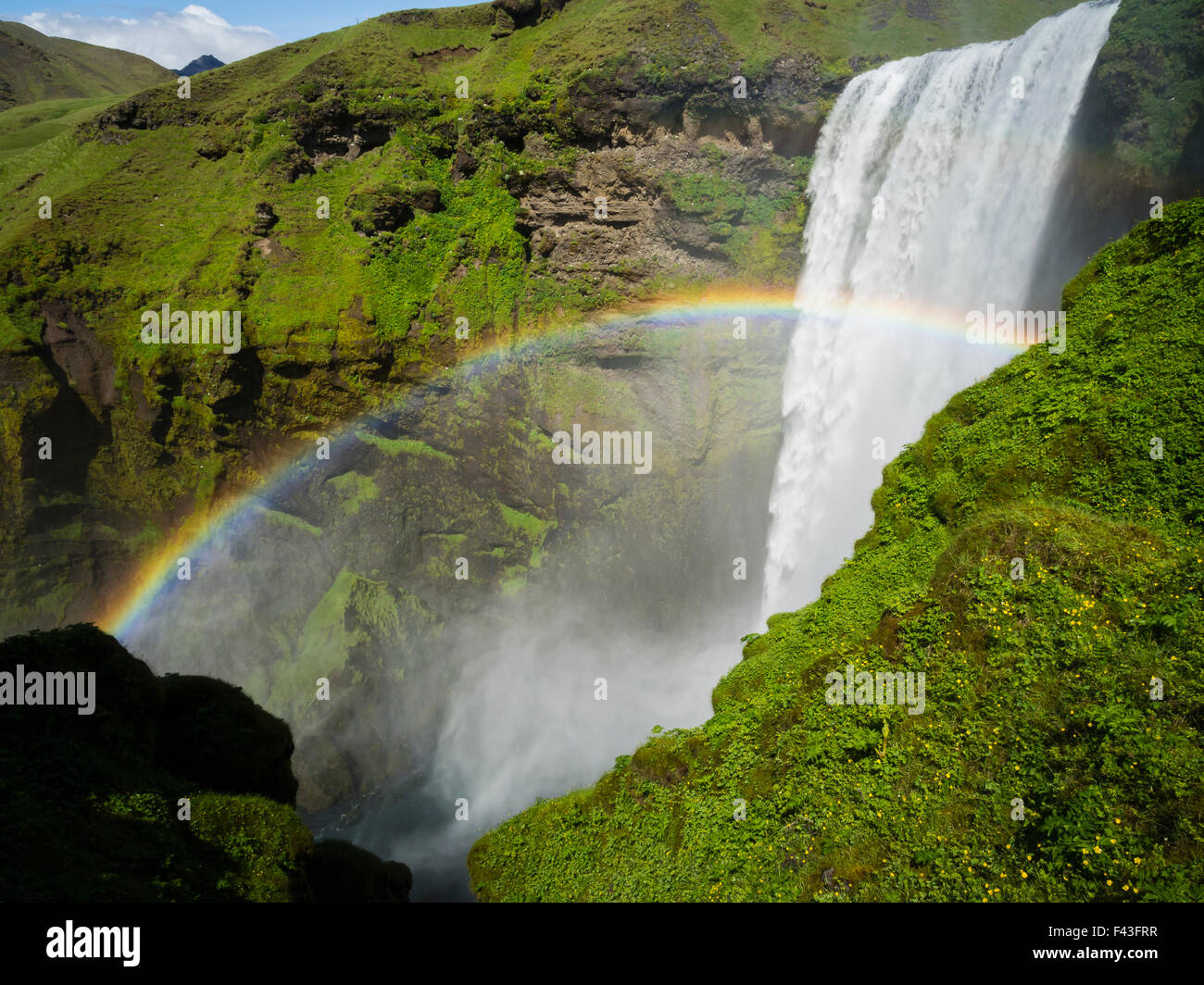 Skogafoss waterfall, a cascade over a sheer cliff, and a rainbow in the ...