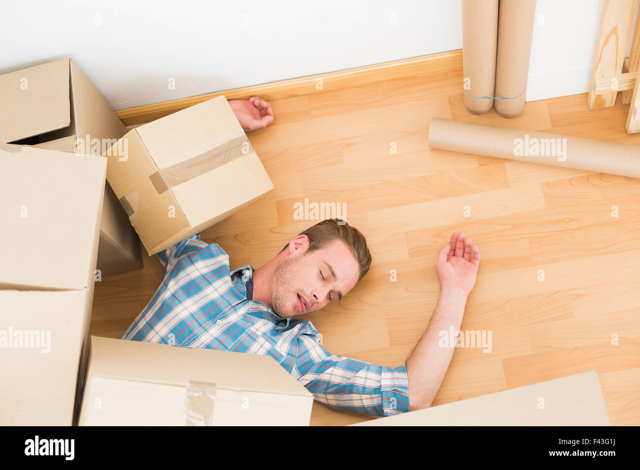 Man lying under fallen boxes Stock Photo - Alamy