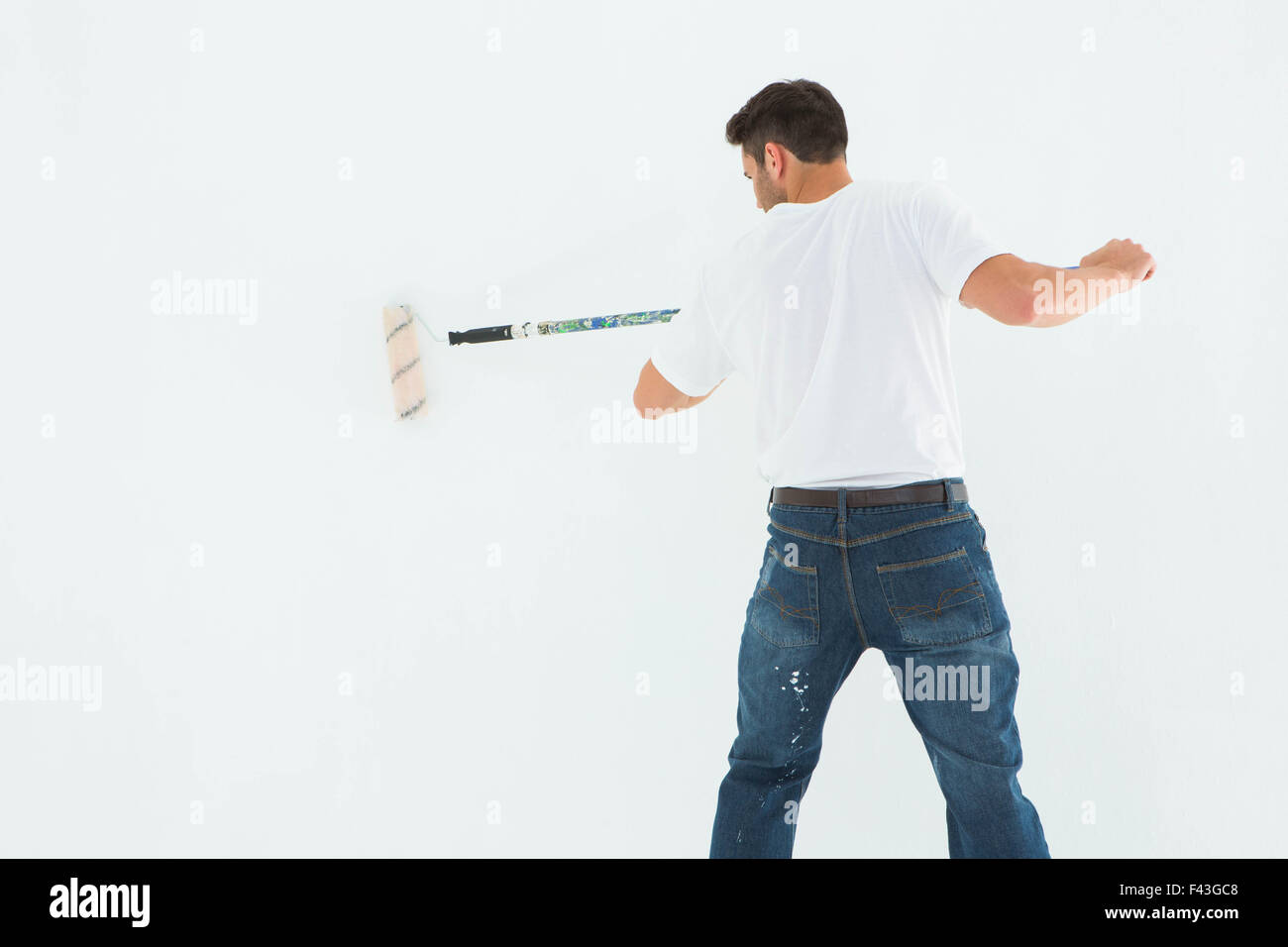 Man using paint roller on white background Stock Photo - Alamy