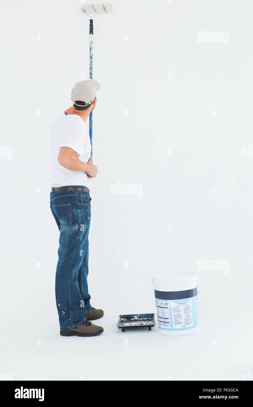 Man using paint roller on white background Stock Photo - Alamy