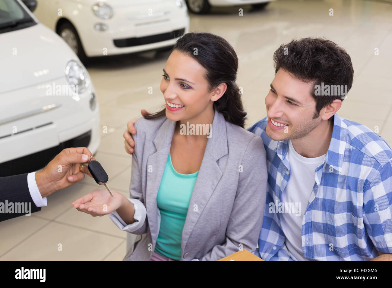 Smiling young couple receiving key Stock Photo - Alamy
