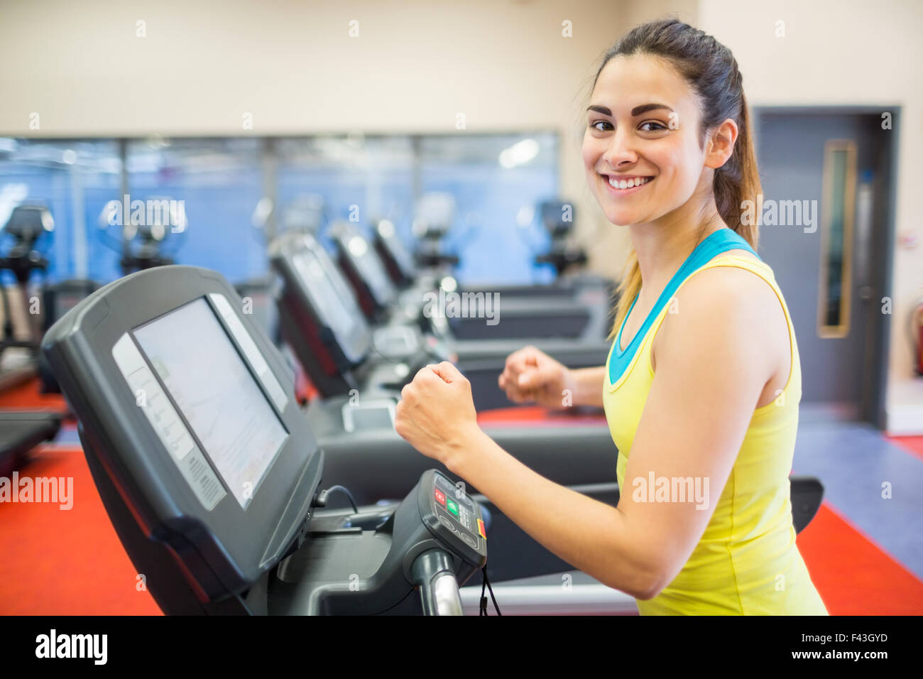 Smiling woman running on a treadmill Stock Photo - Alamy