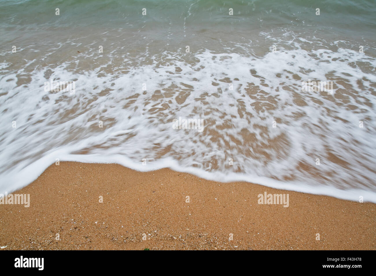 Sea wave over sand Stock Photo - Alamy
