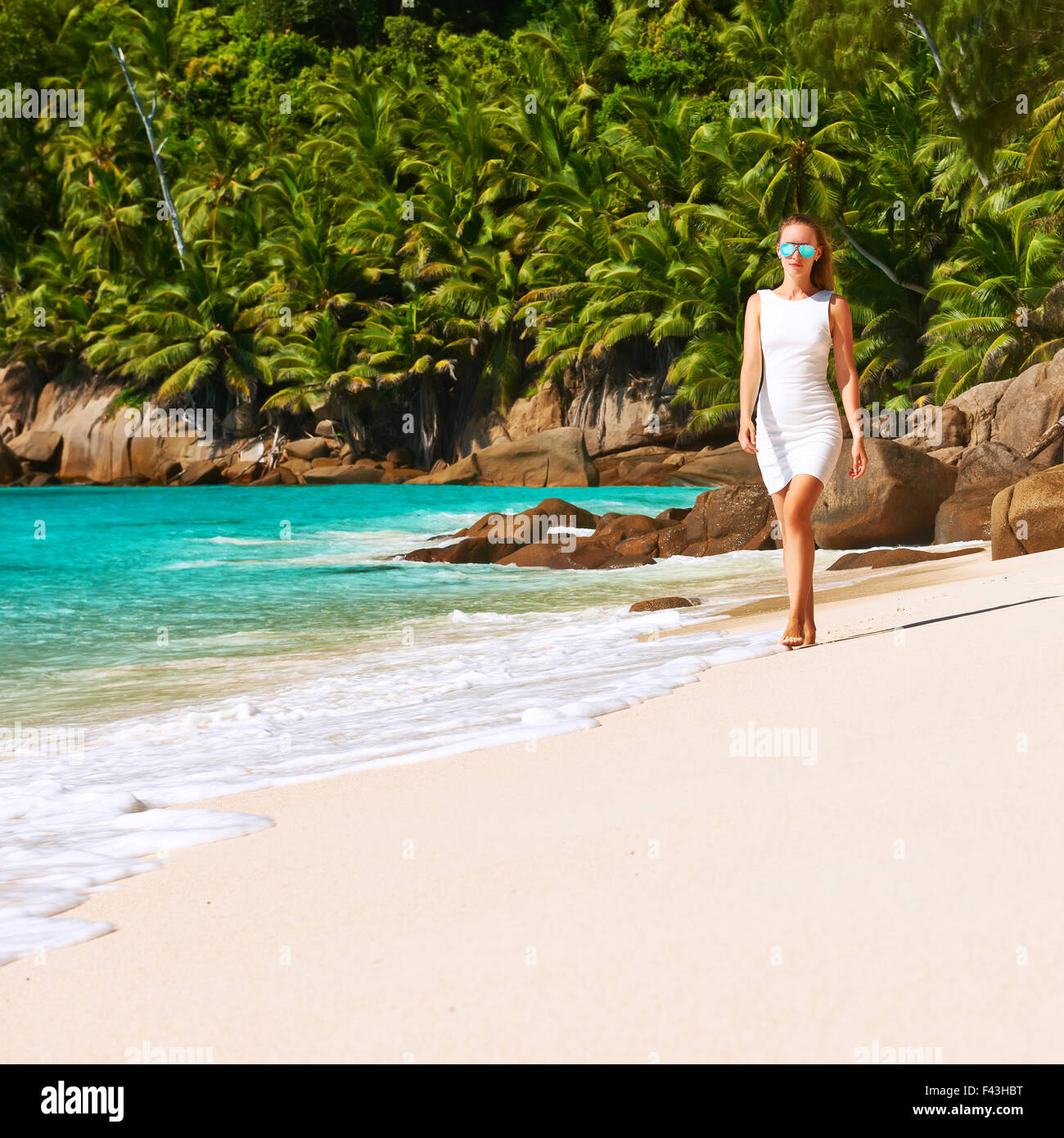 Woman wearing dress on beach at Seychelles Stock Photo - Alamy