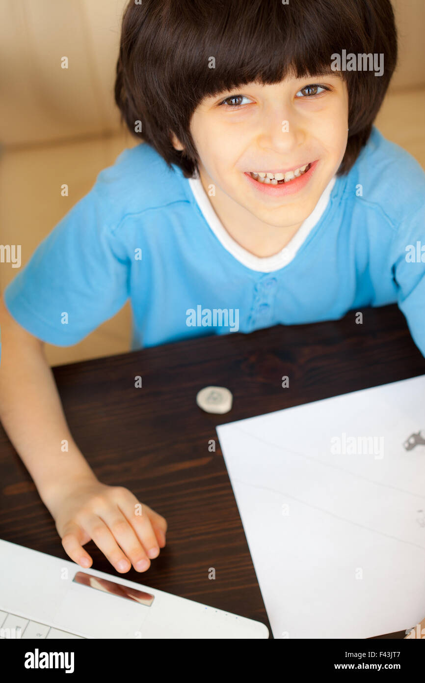 smiling child doing homework with computer Stock Photo - Alamy