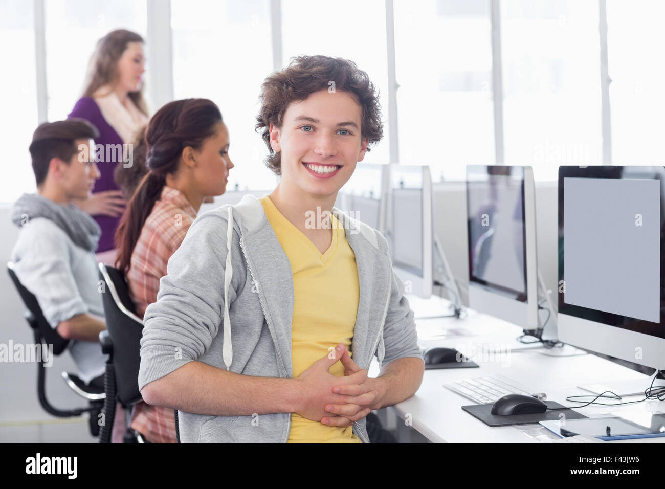 Student smiling at camera in computer class Stock Photo - Alamy