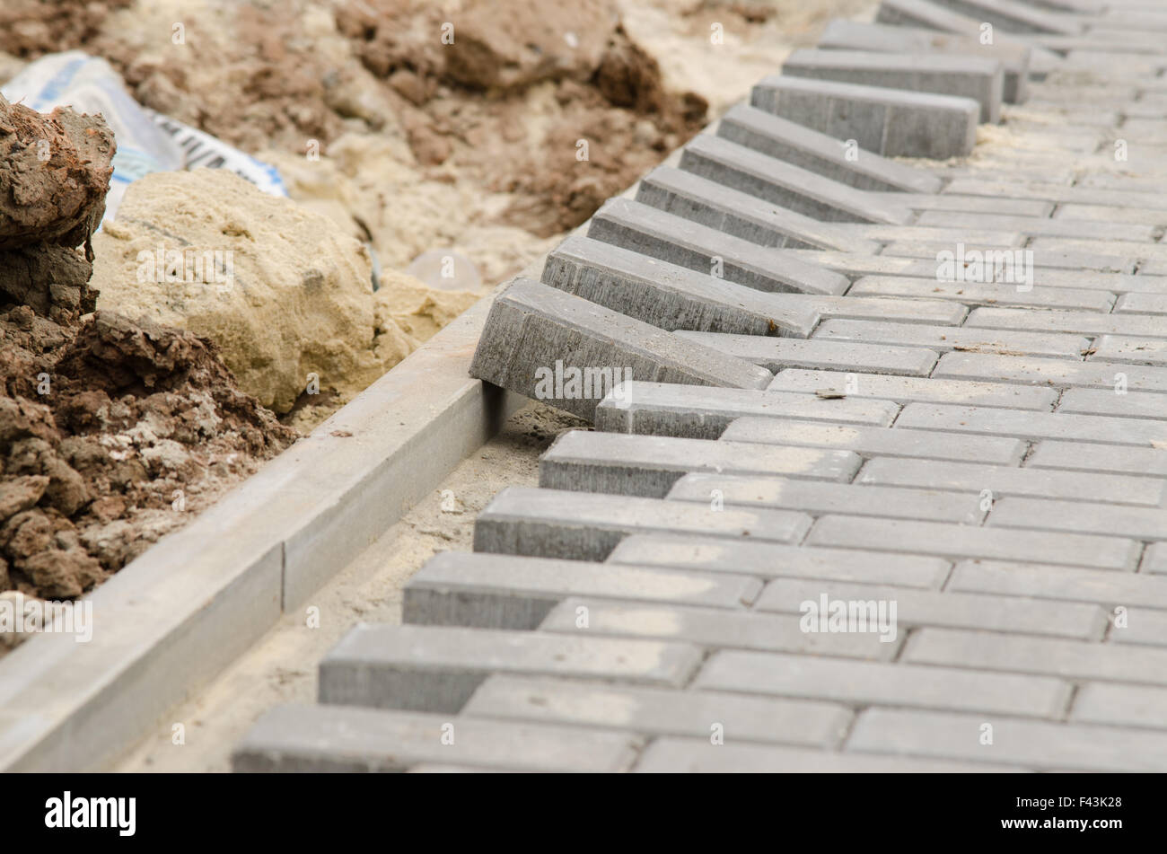 Laying of paving slabs to curb Stock Photo - Alamy