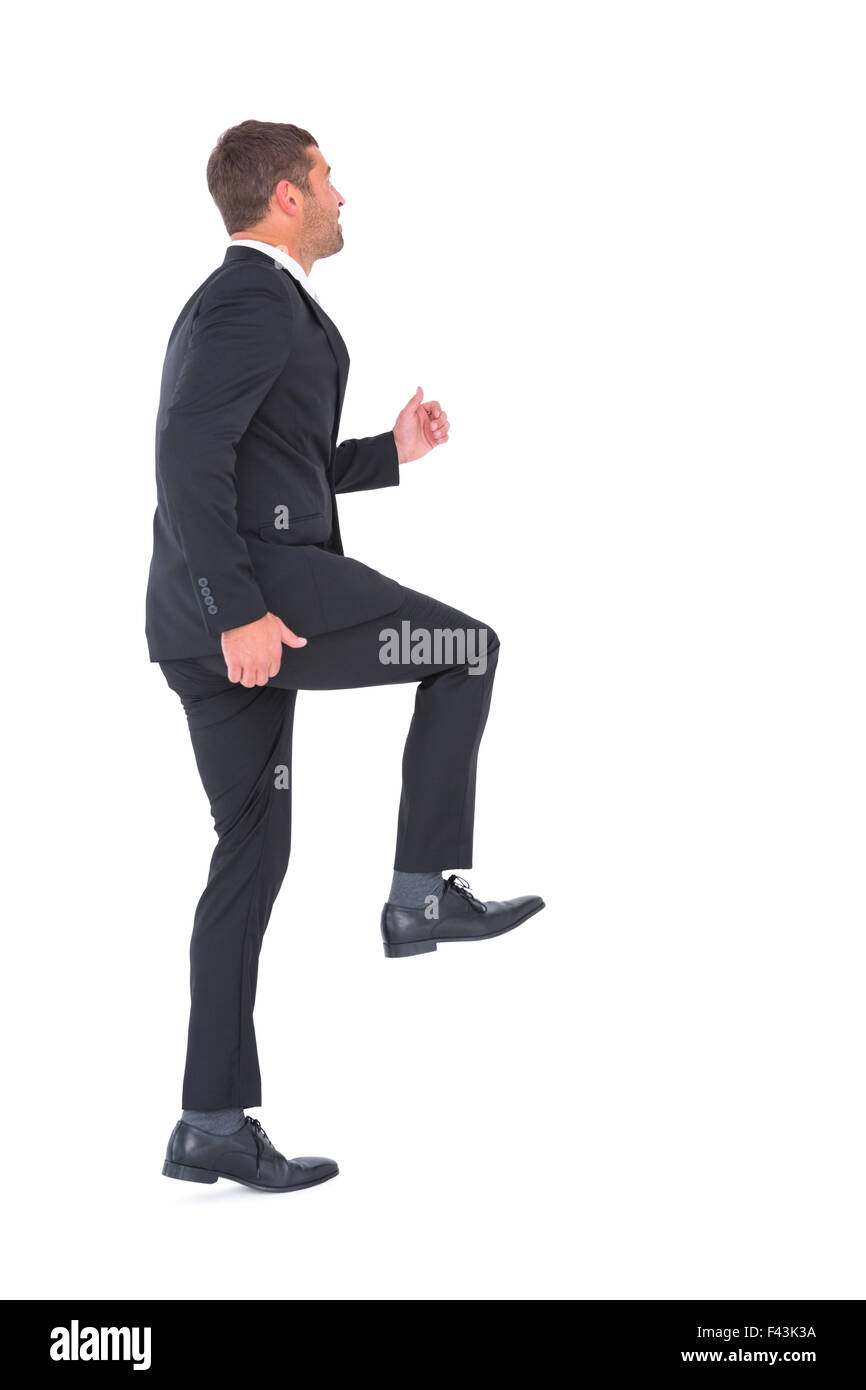 Businessman walking with his leg up Stock Photo - Alamy