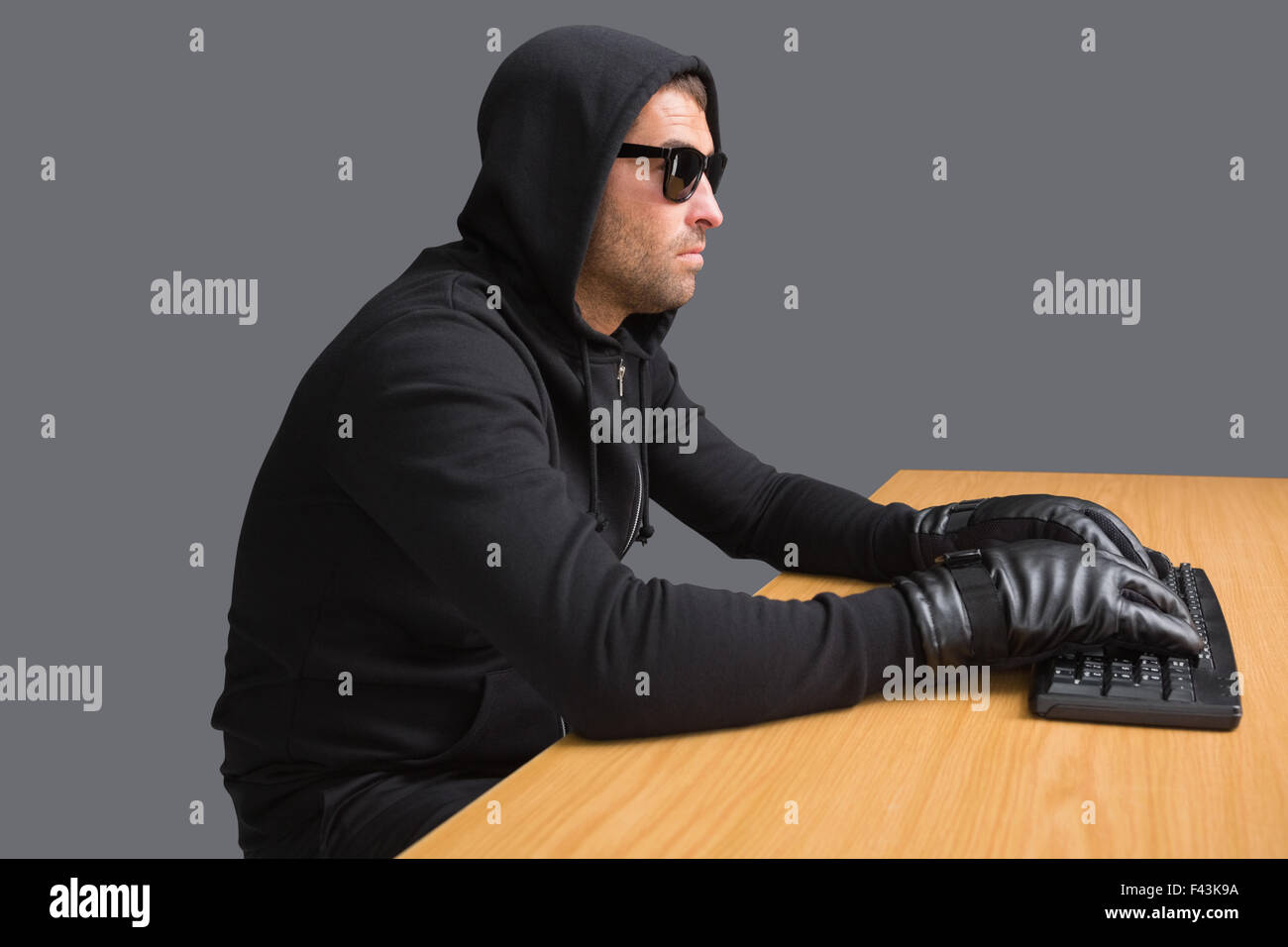 Serious burglar hacking into laptop Stock Photo - Alamy