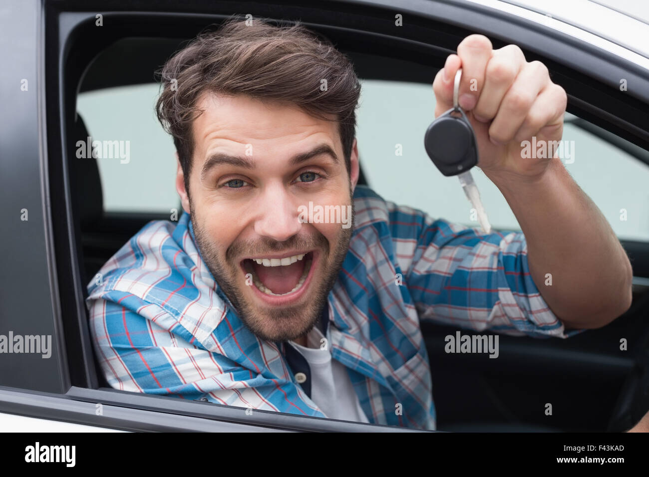Young man smiling and holding key Stock Photo - Alamy