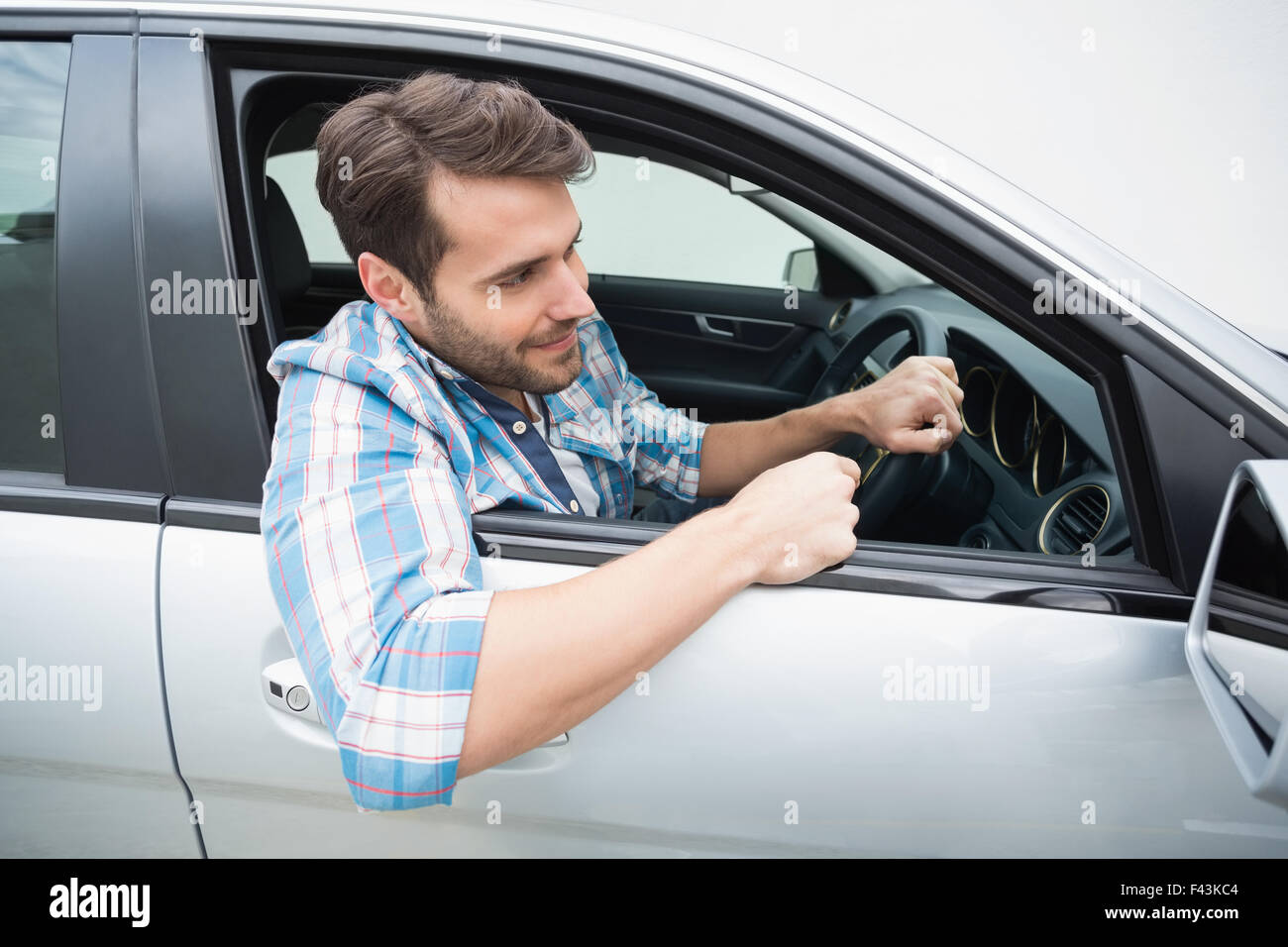 Young man smiling and driving Stock Photo - Alamy
