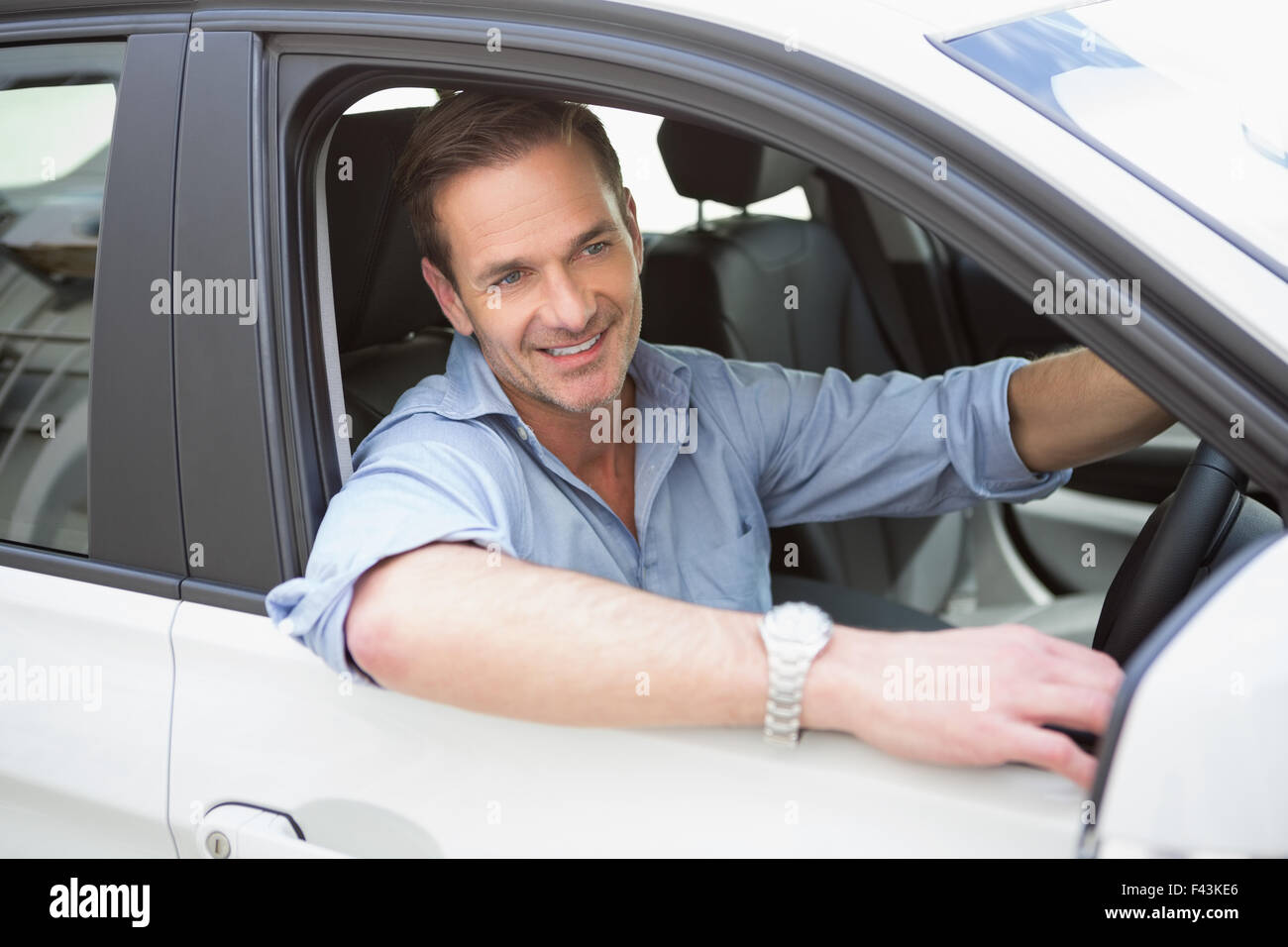 Handsome man smiling at camera Stock Photo - Alamy