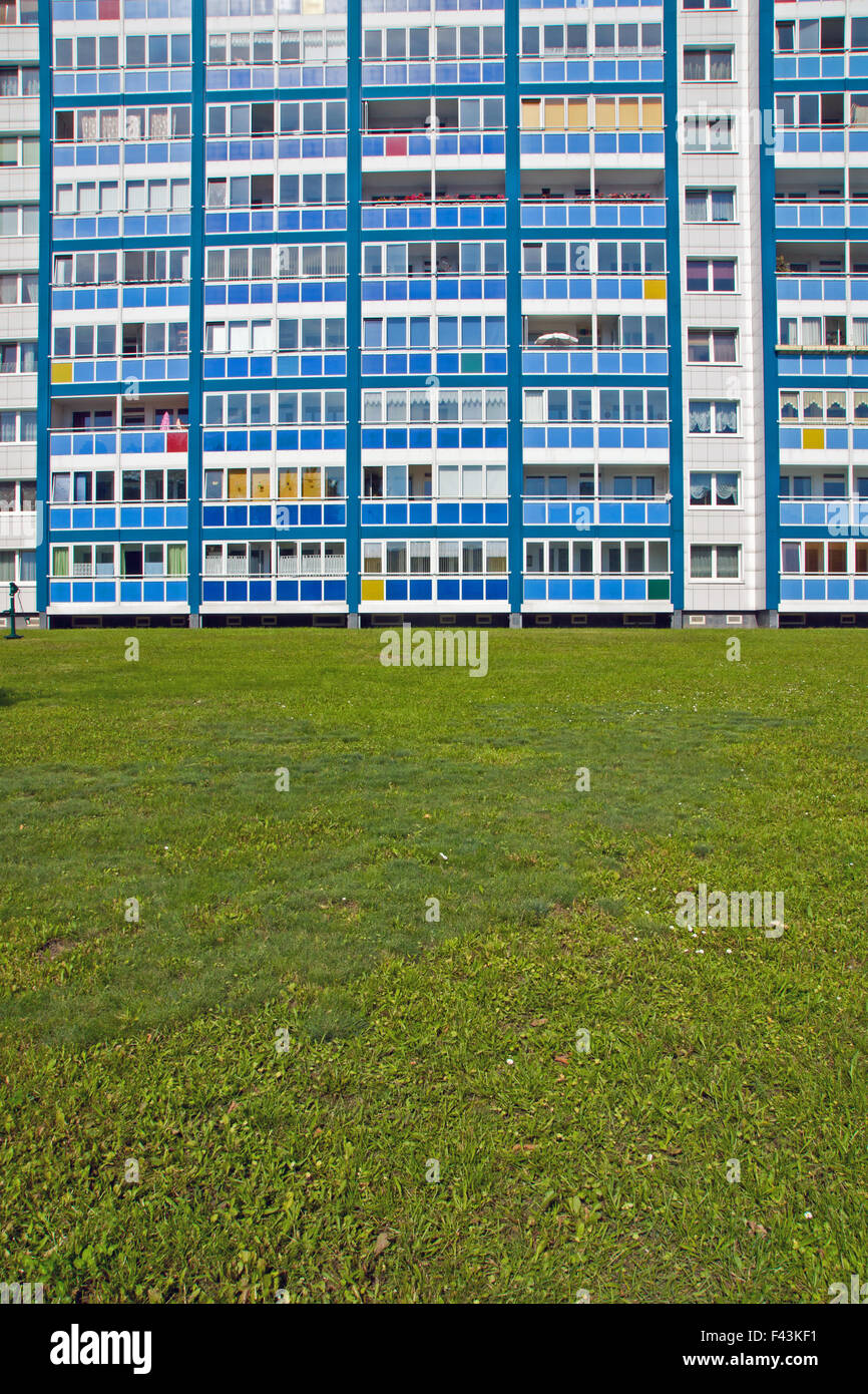 A blue apartment building with green grass in front of it Stock Photo ...