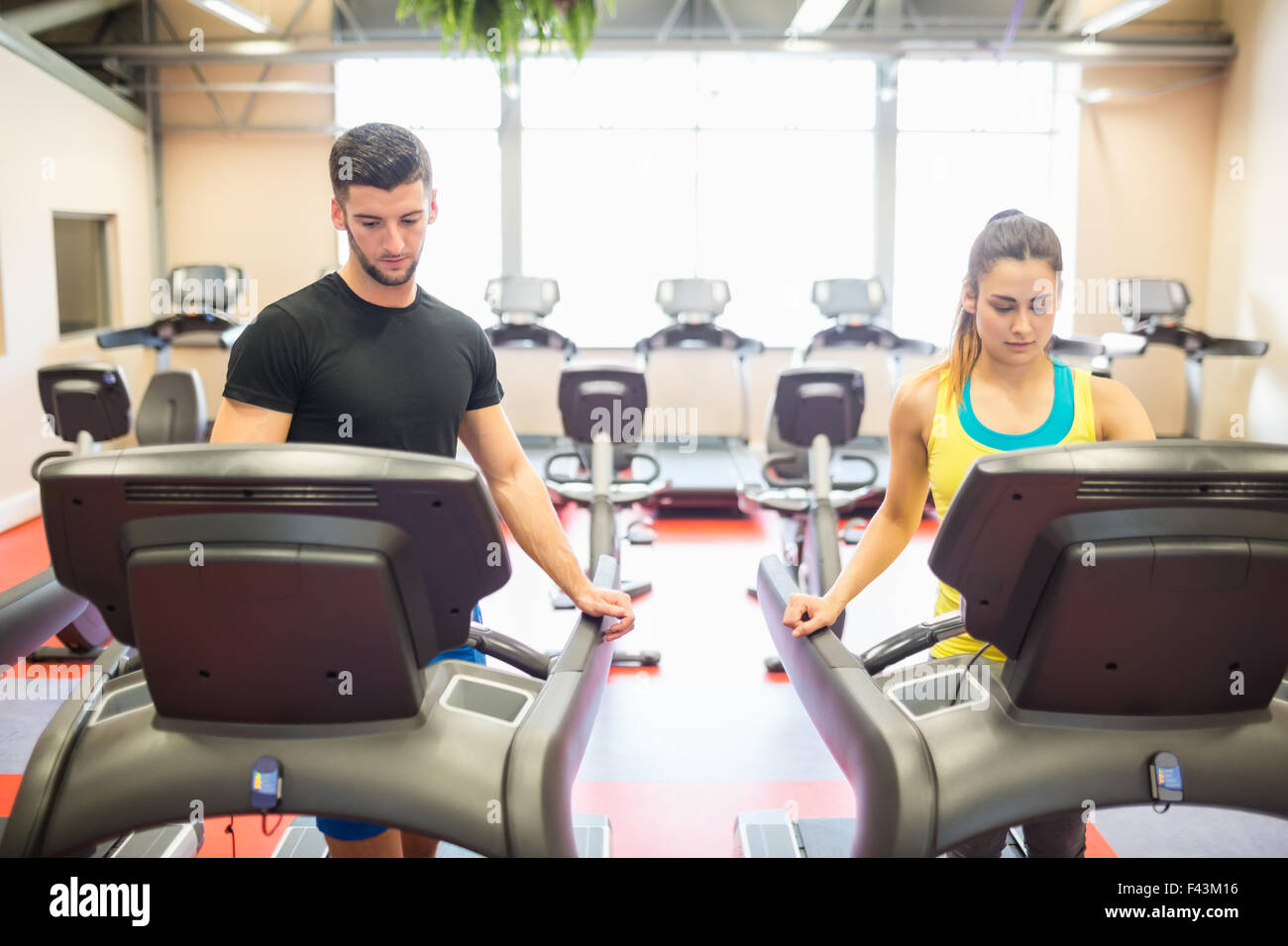 Man and woman using treadmills Stock Photo - Alamy