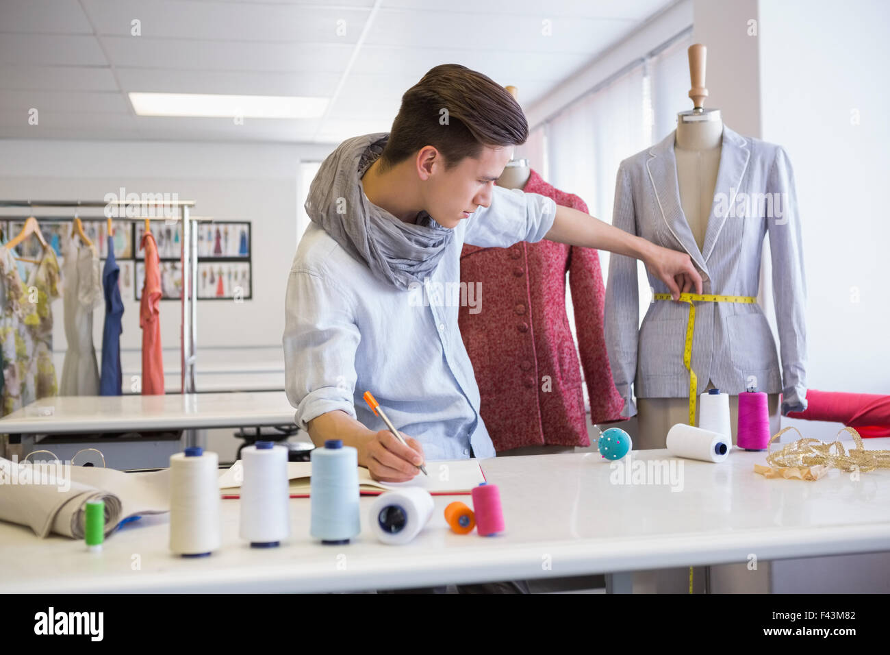 Fashion student taking notes and measuring Stock Photo - Alamy