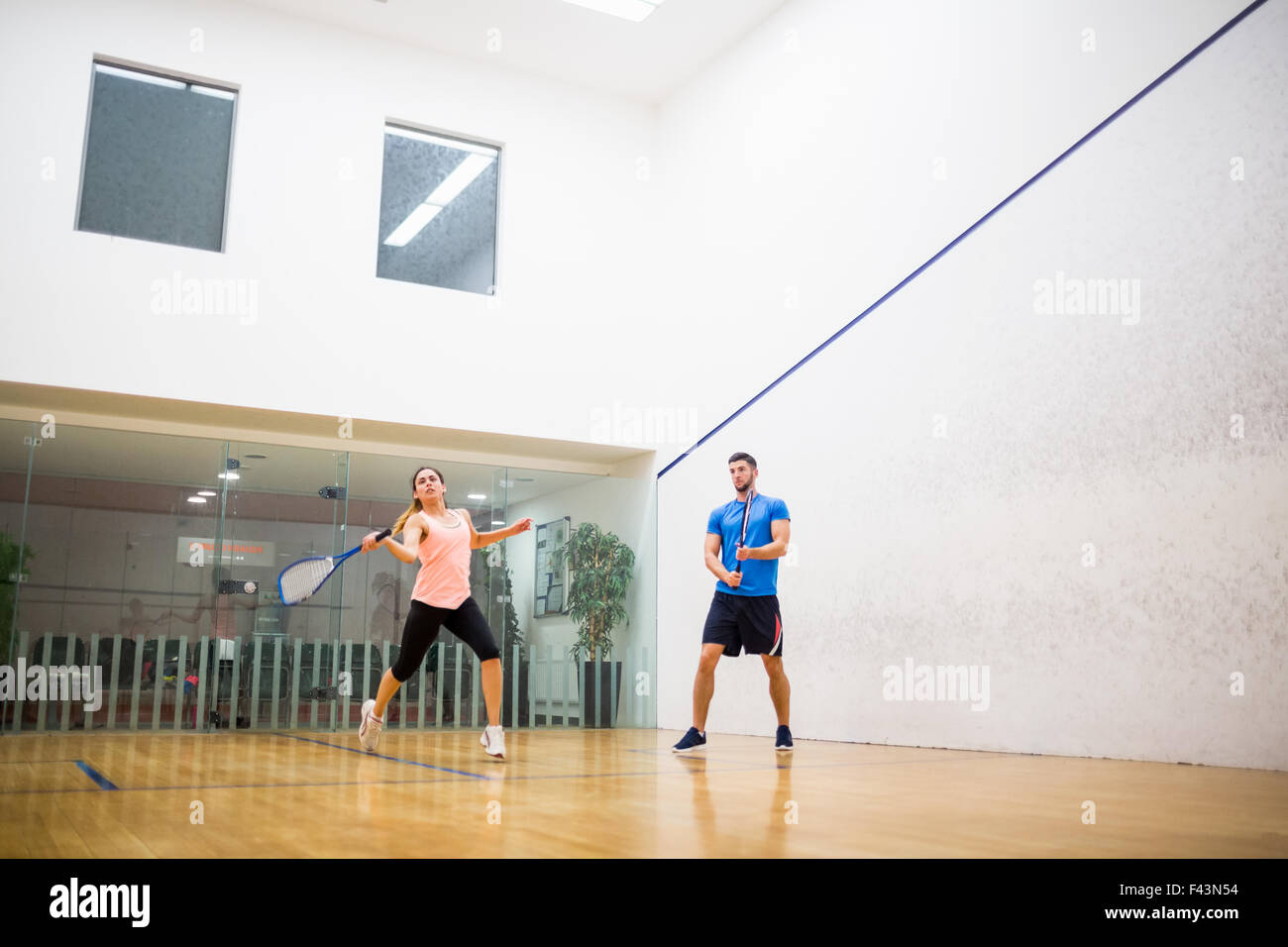 Couple playing a game of squash Stock Photo - Alamy