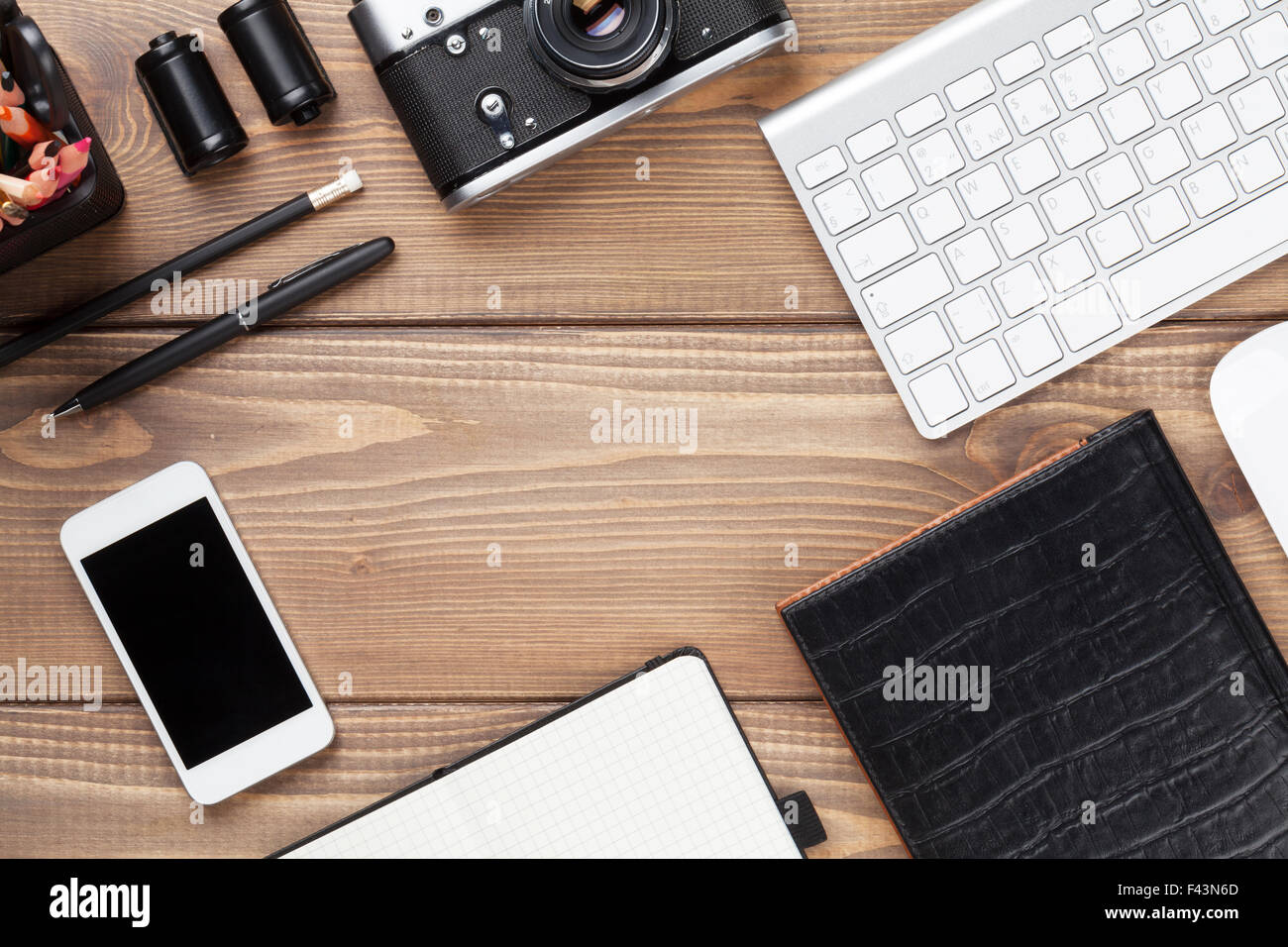 Office desk table with computer, supplies and camera. Top view with ...