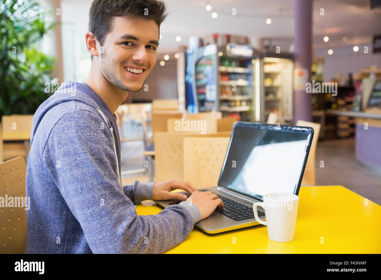 Young student using his laptop in cafe Stock Photo - Alamy