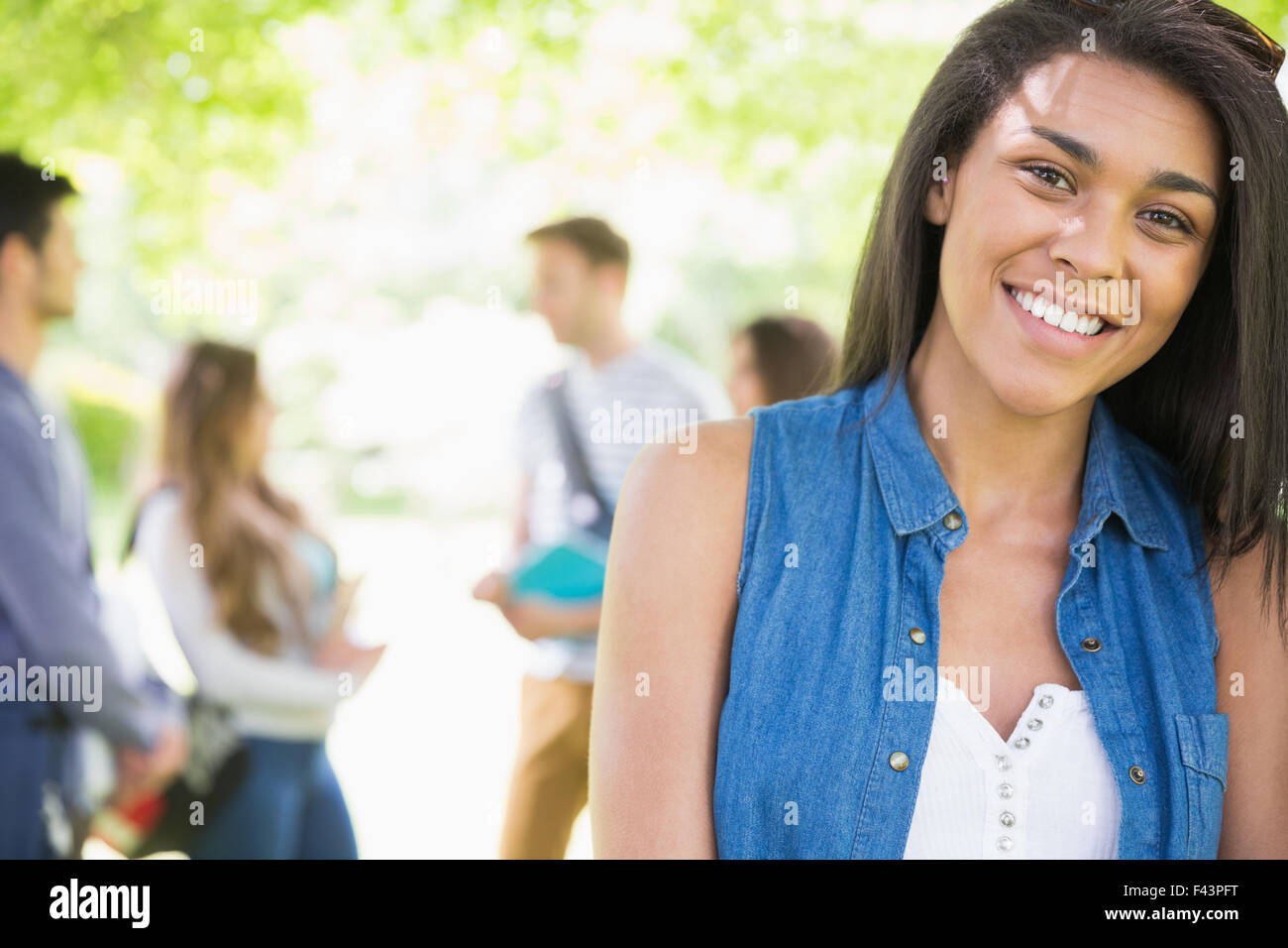 Pretty student smiling at camera outside Stock Photo - Alamy