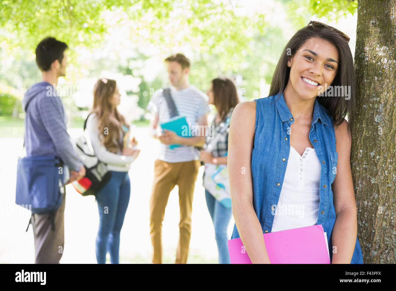 Pretty student smiling at camera outside Stock Photo - Alamy