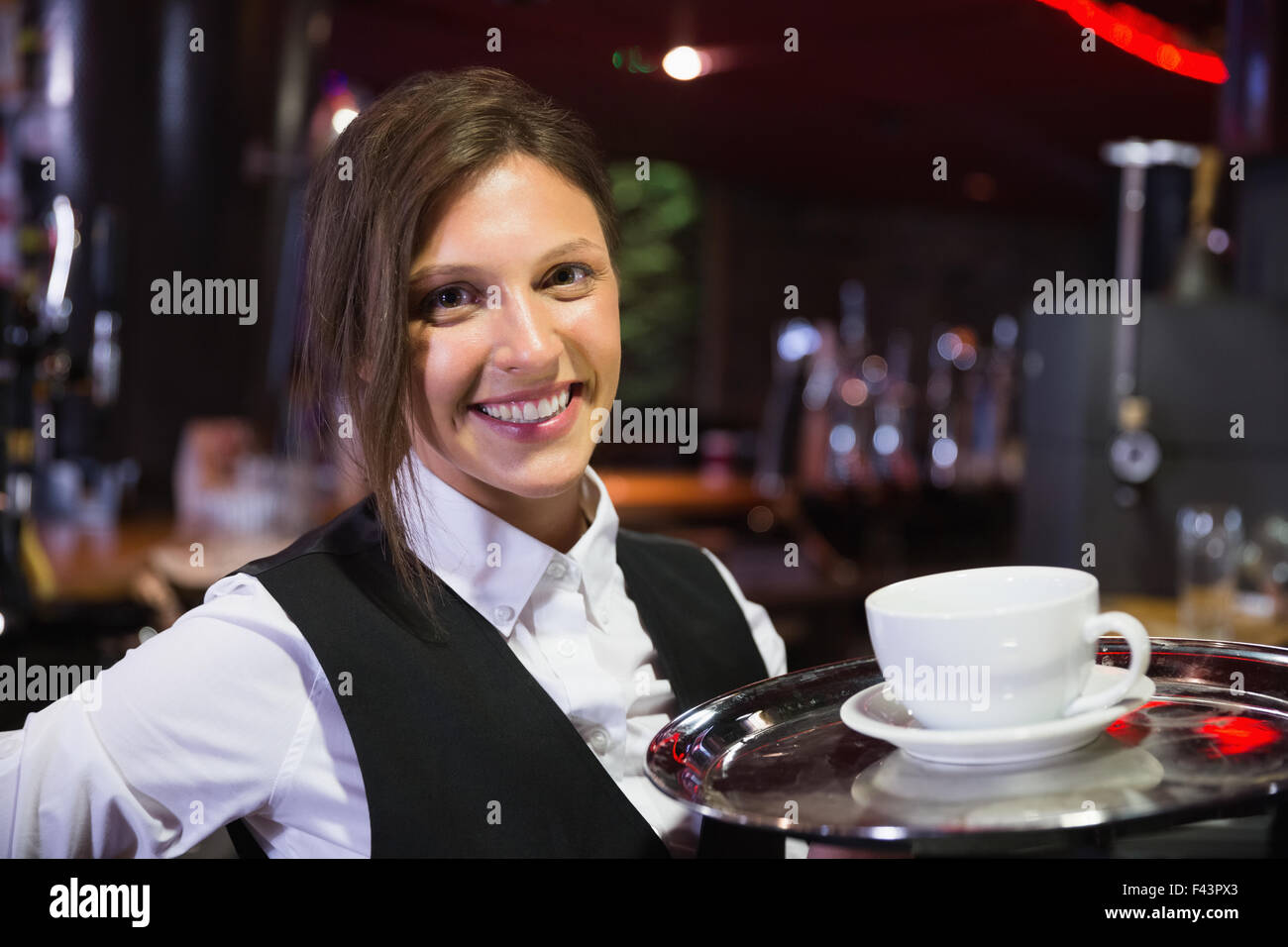 Happy barmaid holding tray with coffee Stock Photo - Alamy