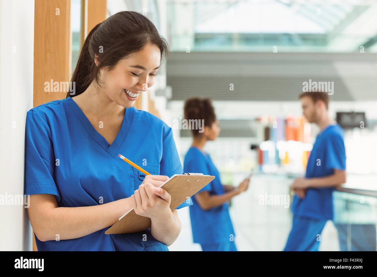 Medical student taking notes in hallway Stock Photo - Alamy