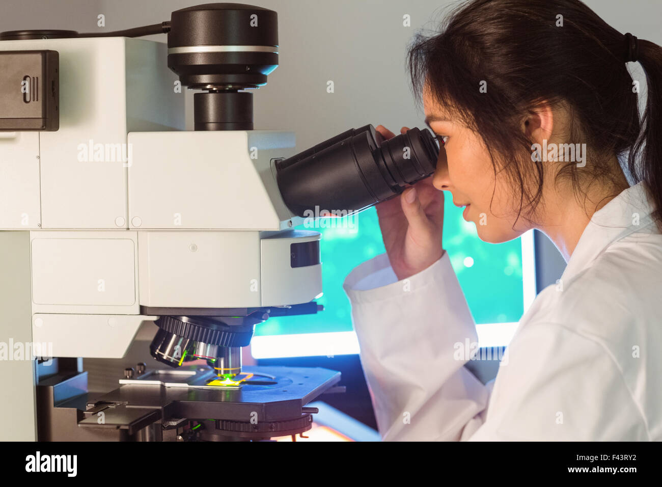 Science student looking through microscope Stock Photo - Alamy