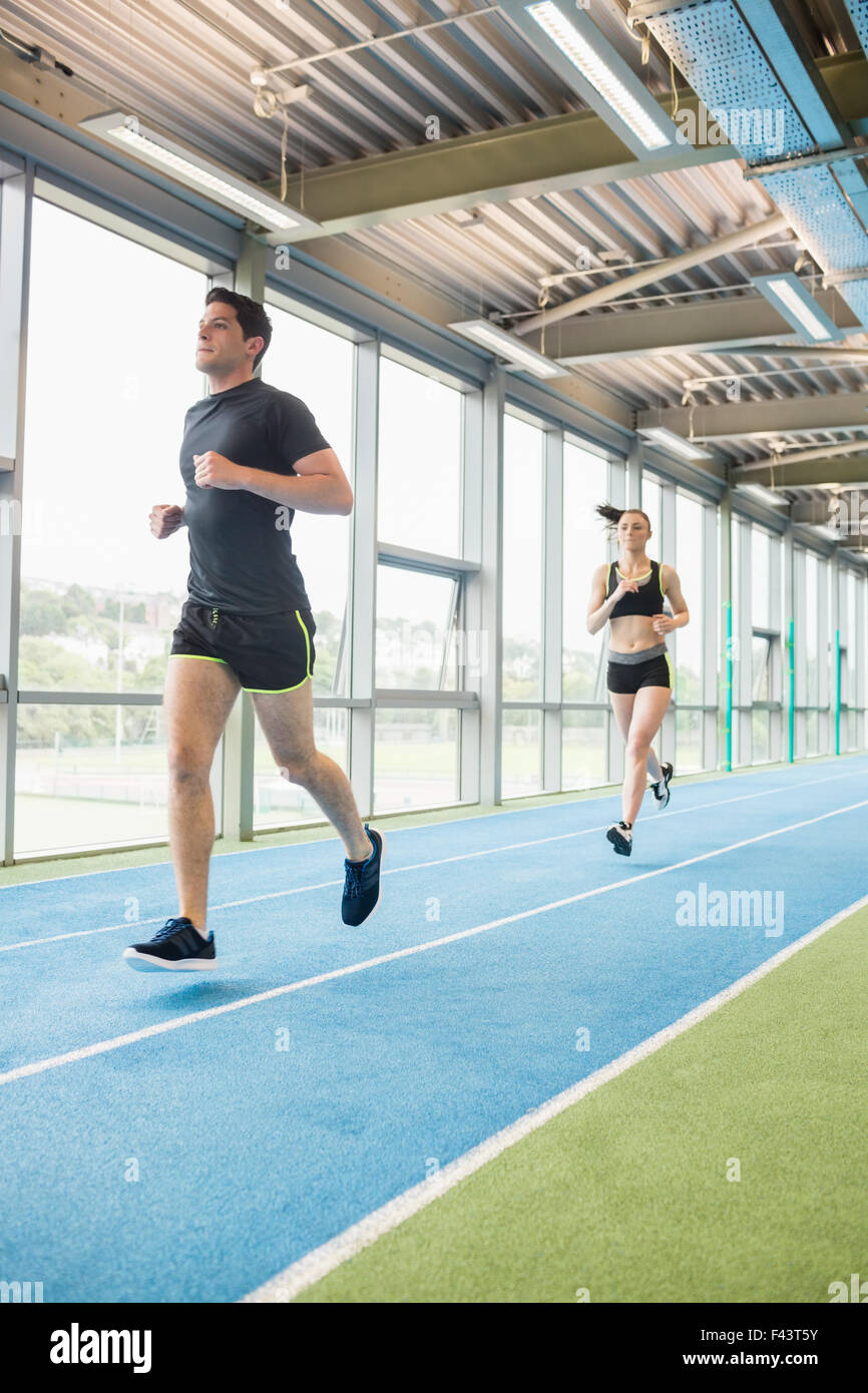 Couple running on the indoor track Stock Photo - Alamy