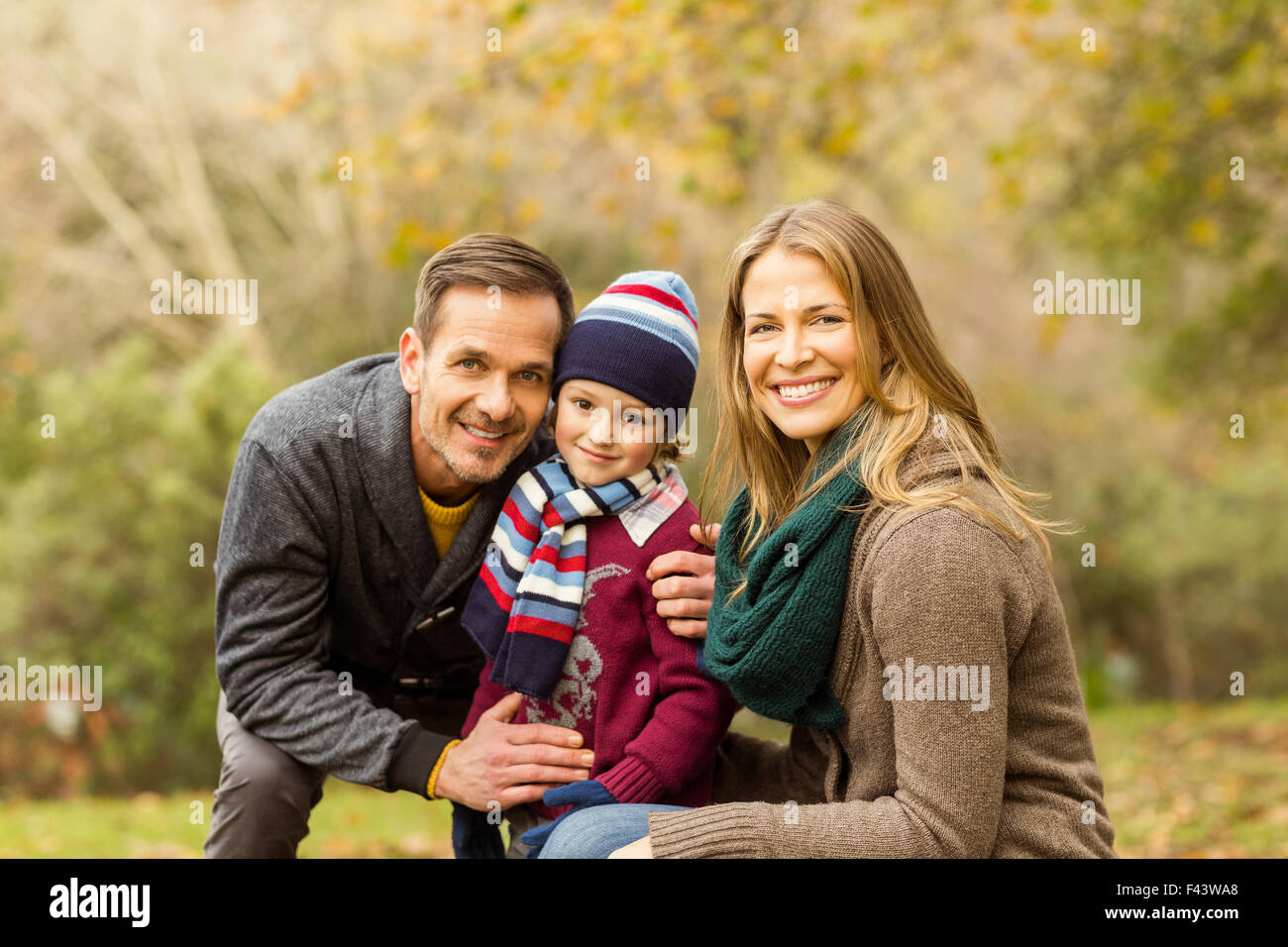 Smiling young couple with little boy posing Stock Photo - Alamy