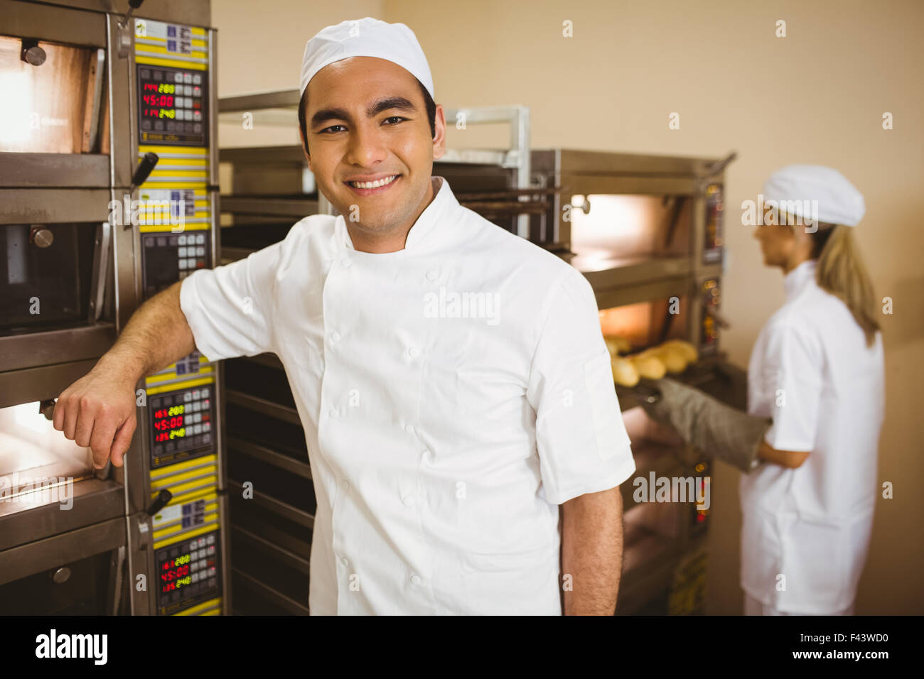 Handsome baker smiling at camera Stock Photo - Alamy