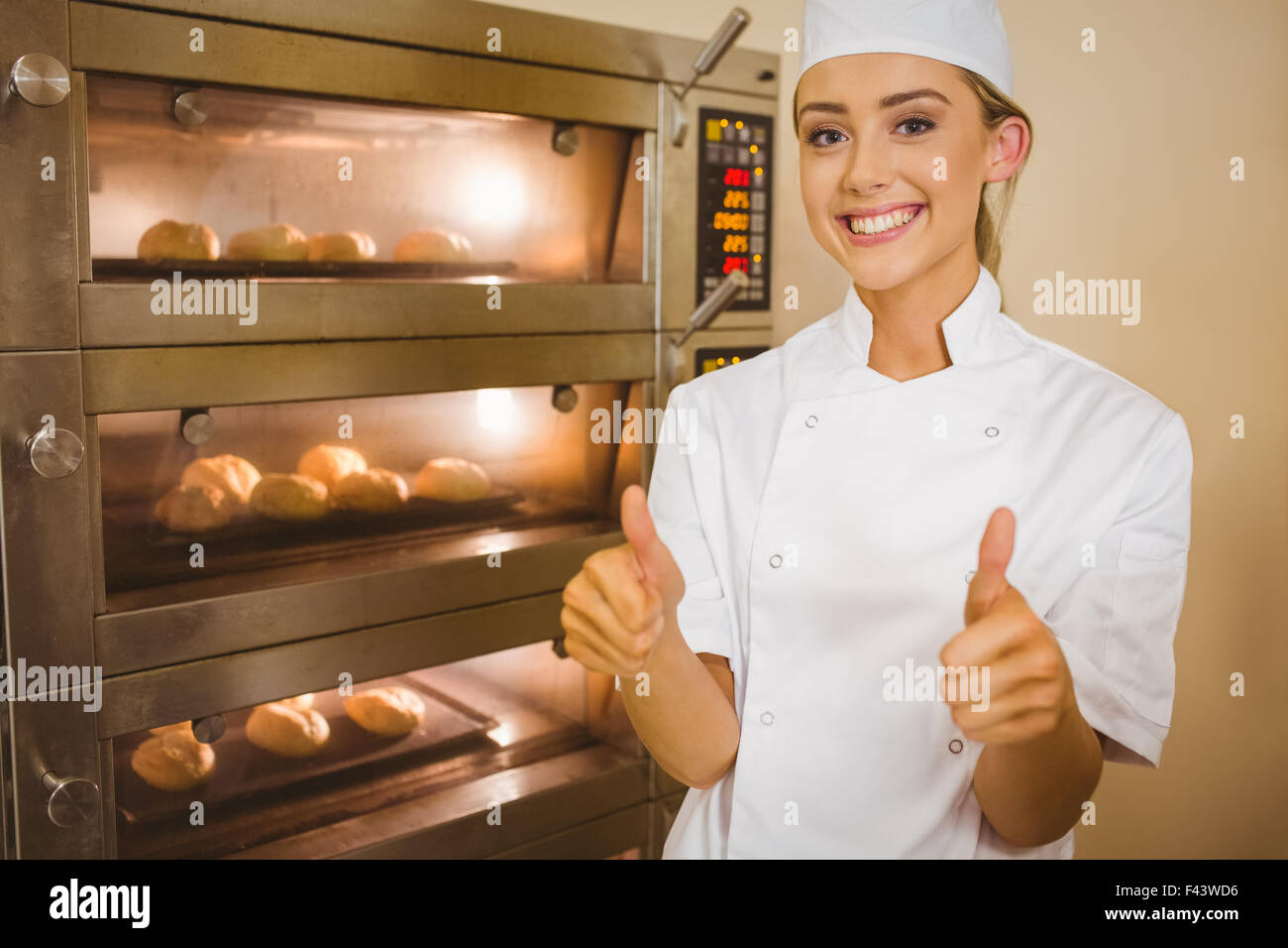 Baker smiling at camera beside oven Stock Photo - Alamy