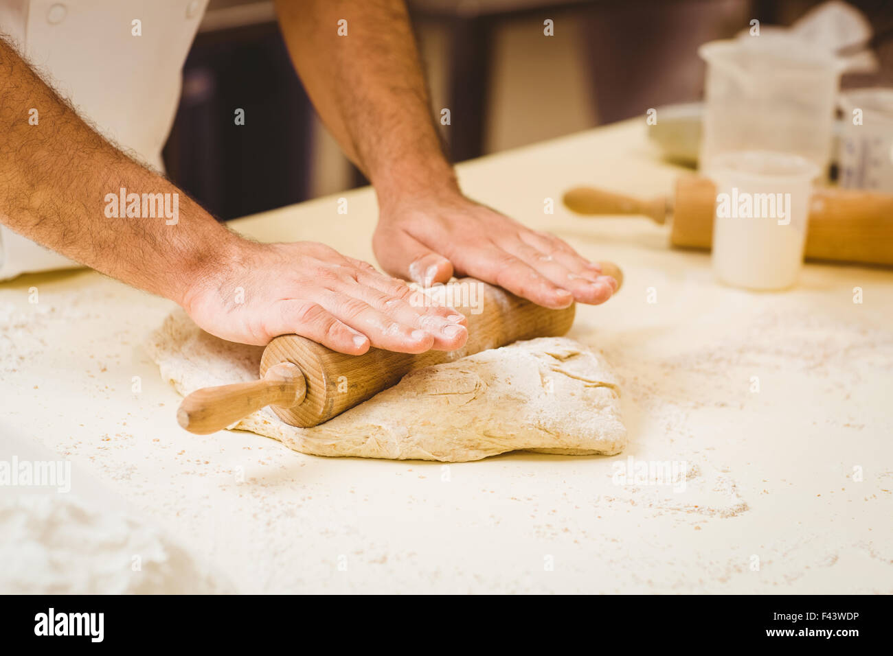 Baker rolling dough at a counter Stock Photo - Alamy