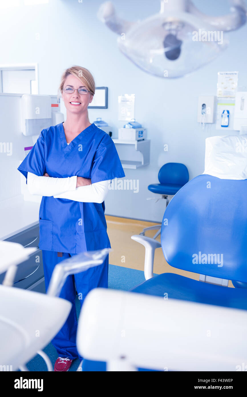 Smiling dentist standing with arms crossed Stock Photo - Alamy