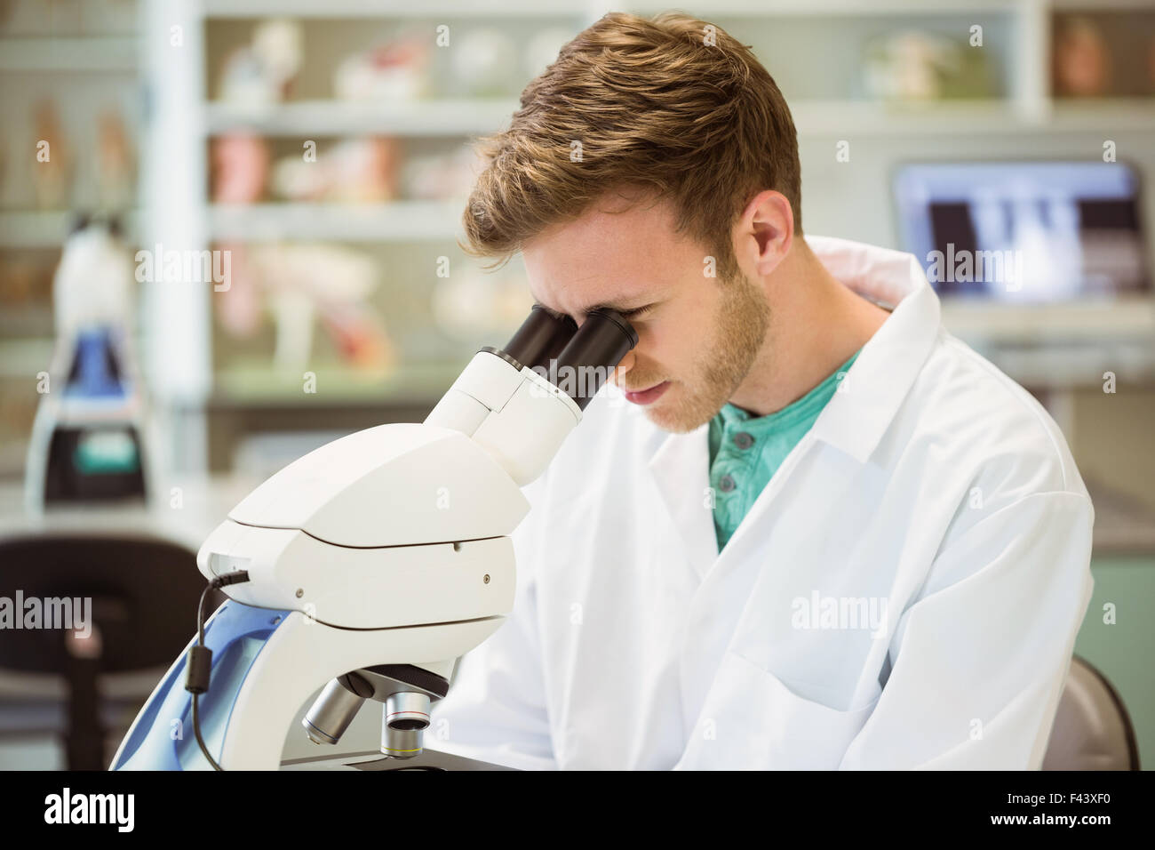 Young scientist looking through microscope Stock Photo - Alamy