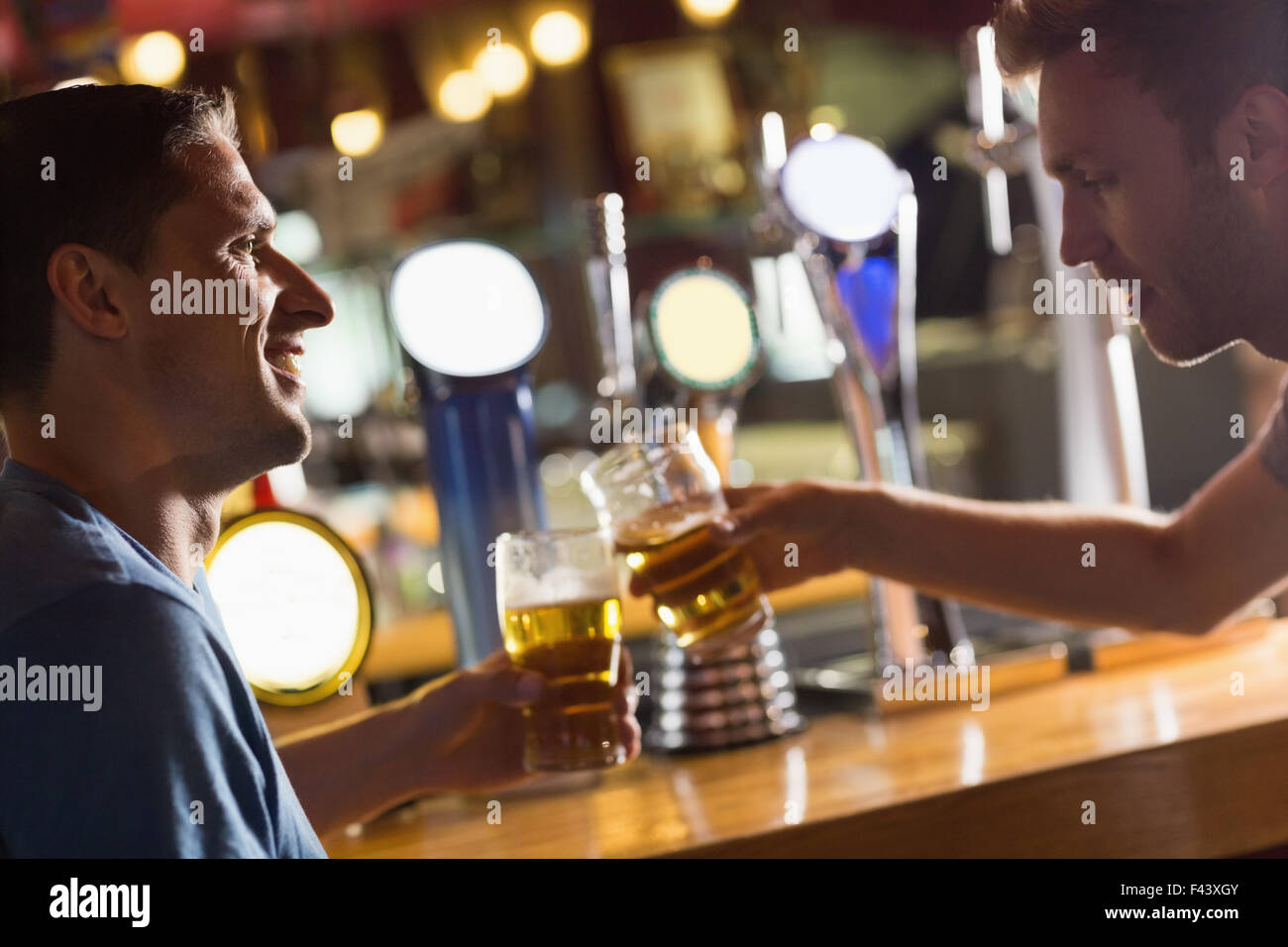 Happy friends catching up over pints Stock Photo - Alamy