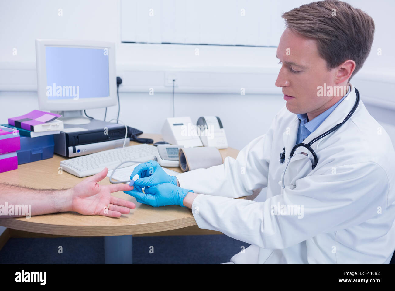 Doctor testing his patients blood Stock Photo - Alamy
