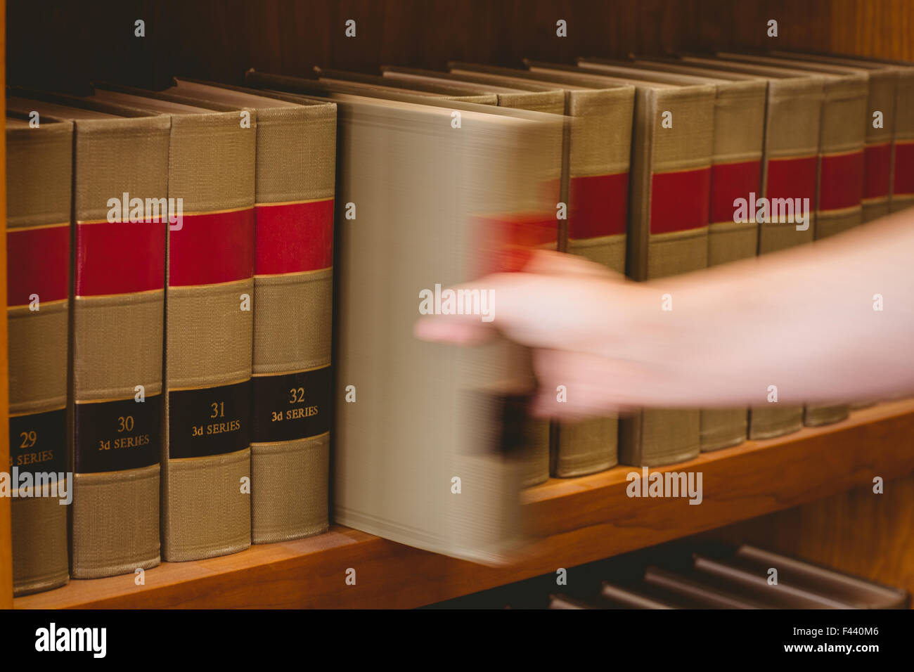 Hand taking a book from bookshelf Stock Photo - Alamy